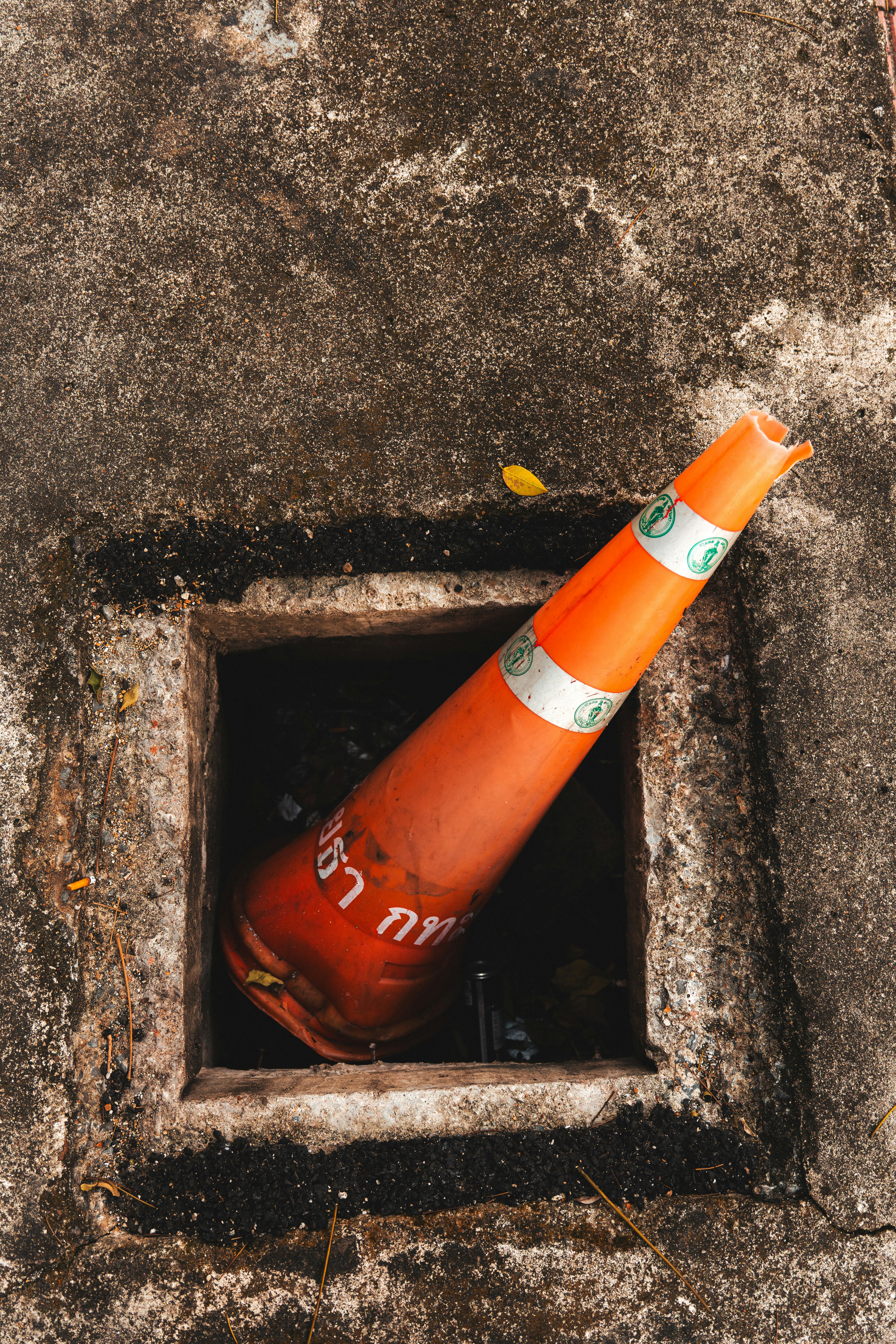 Orange Cone as Oblique Sentinel in a Concrete Square