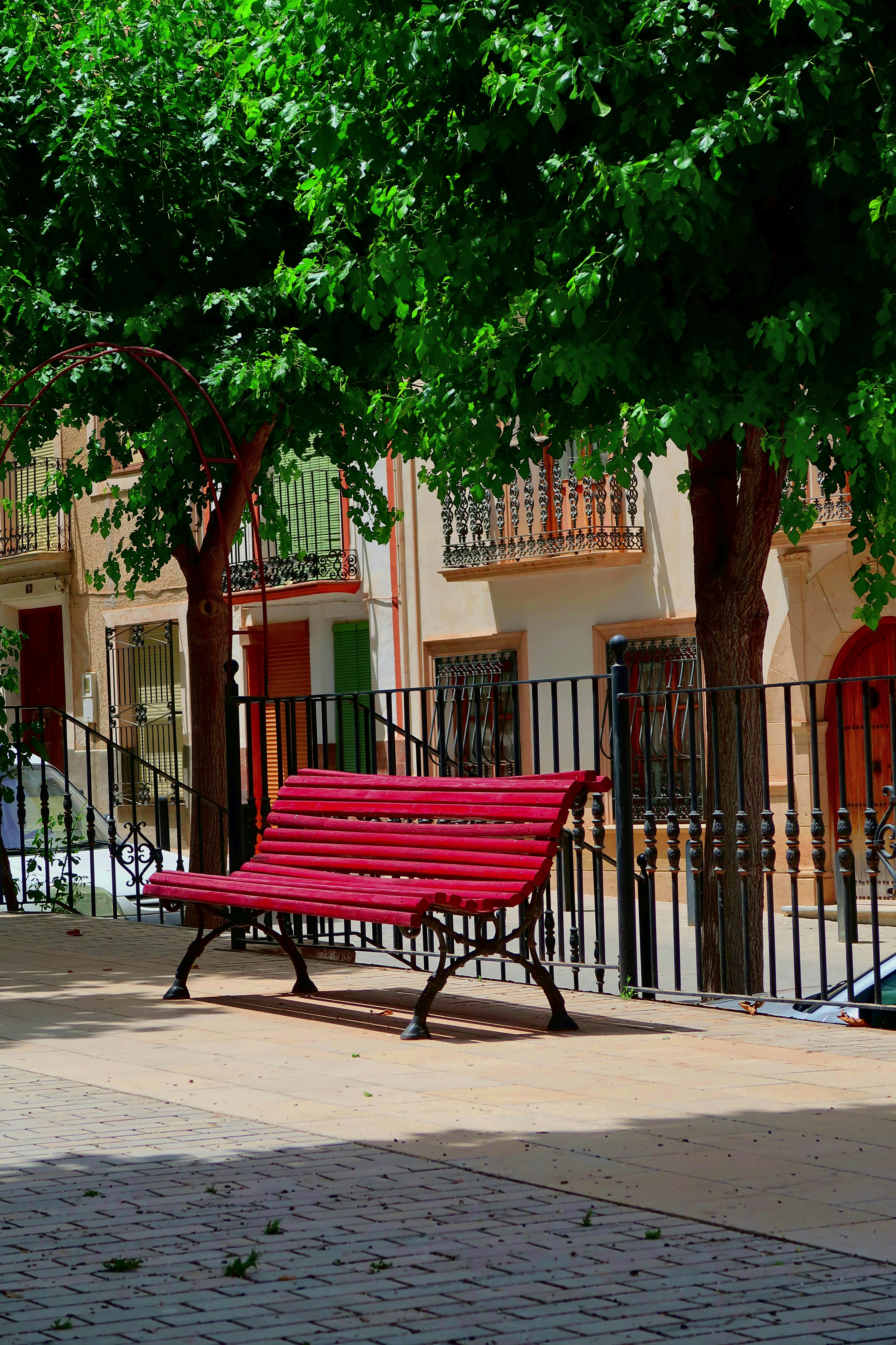 Red Bench in a Sunlit Urban Courtyard