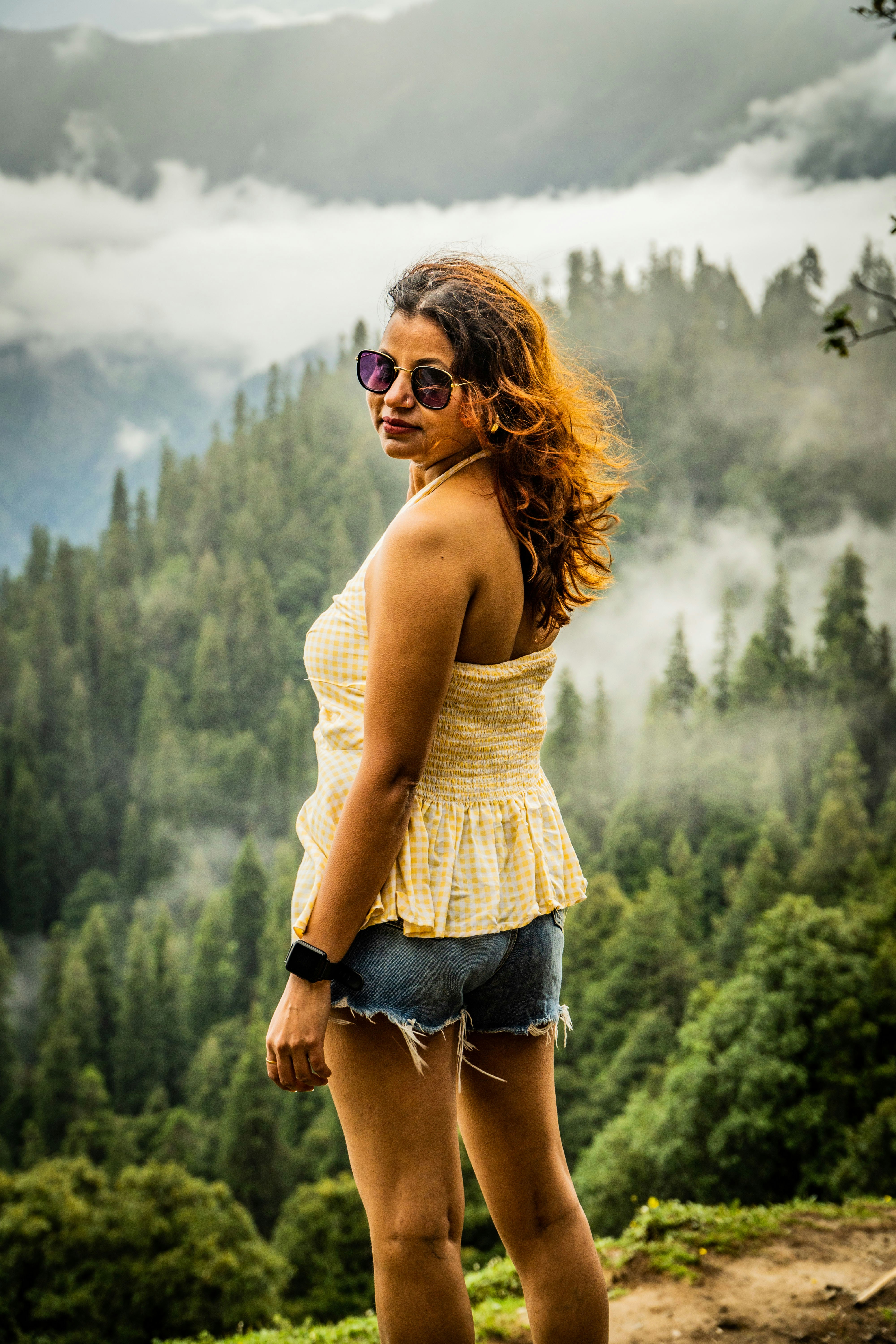Sunlit Wanderer: A Moment Surrounded by Clouds and Pines