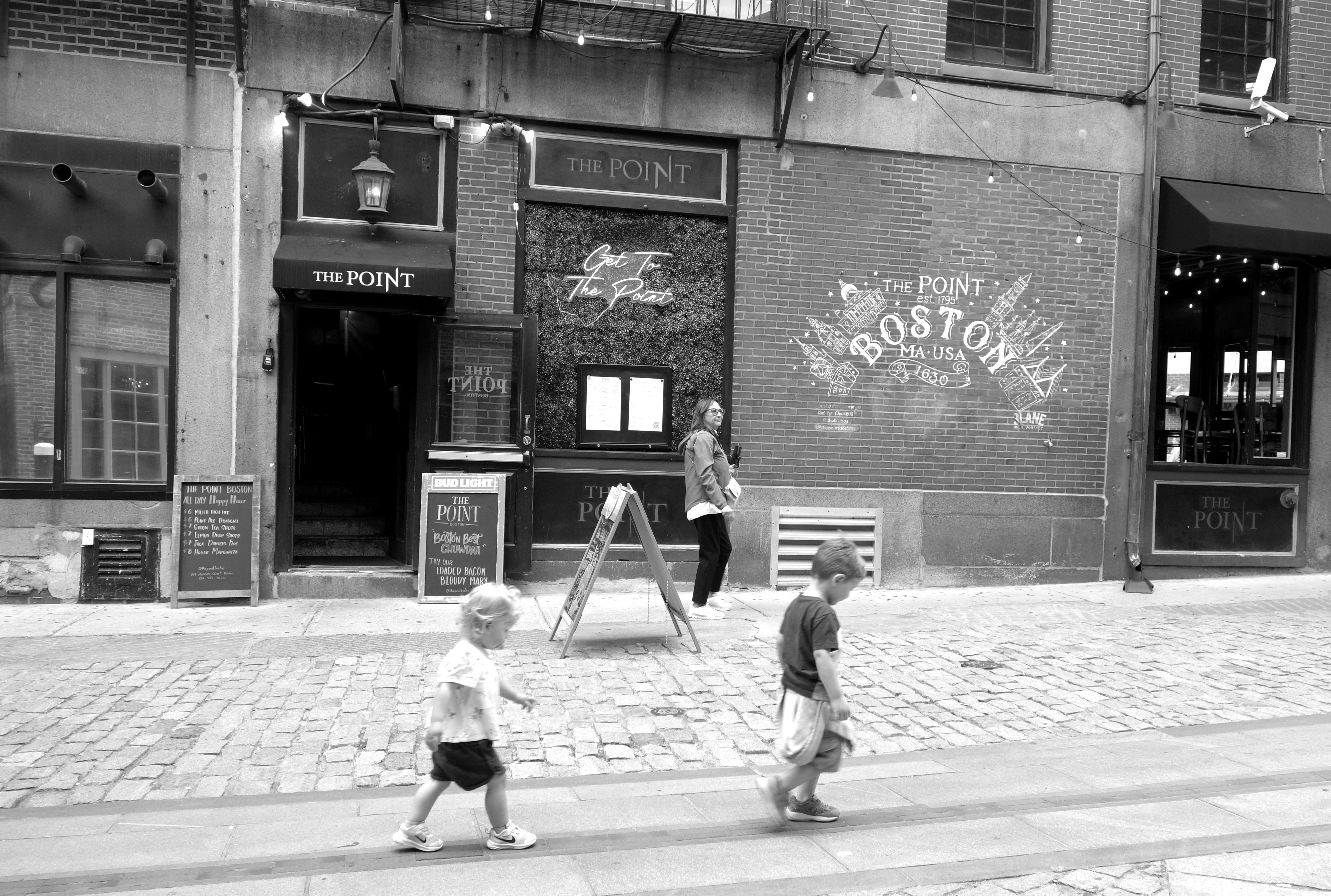 Cobbled Stroll Past The Point: Children, Shopfronts, and a Quiet Street