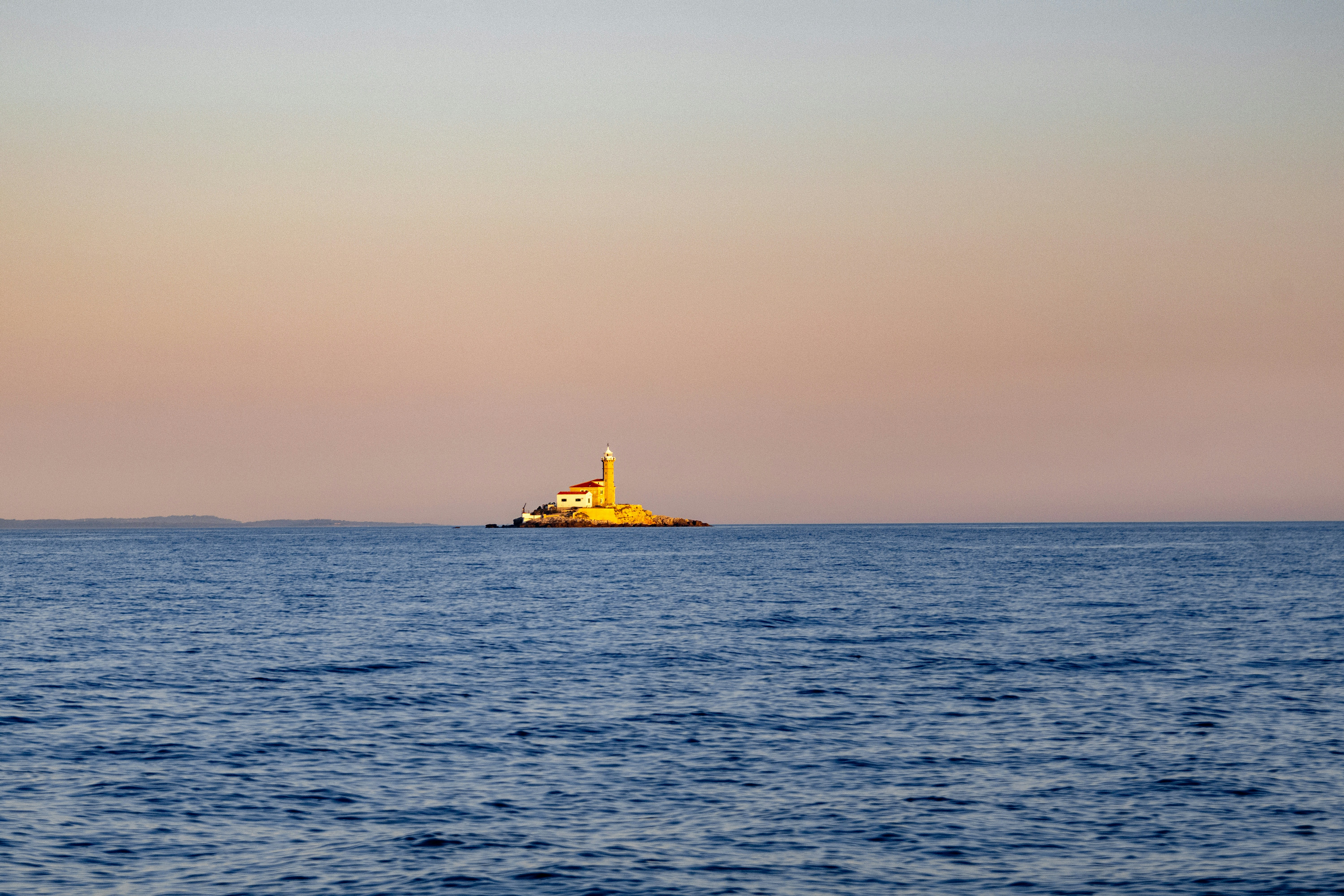 Lone Lighthouse on a Calm Sea at Sunset