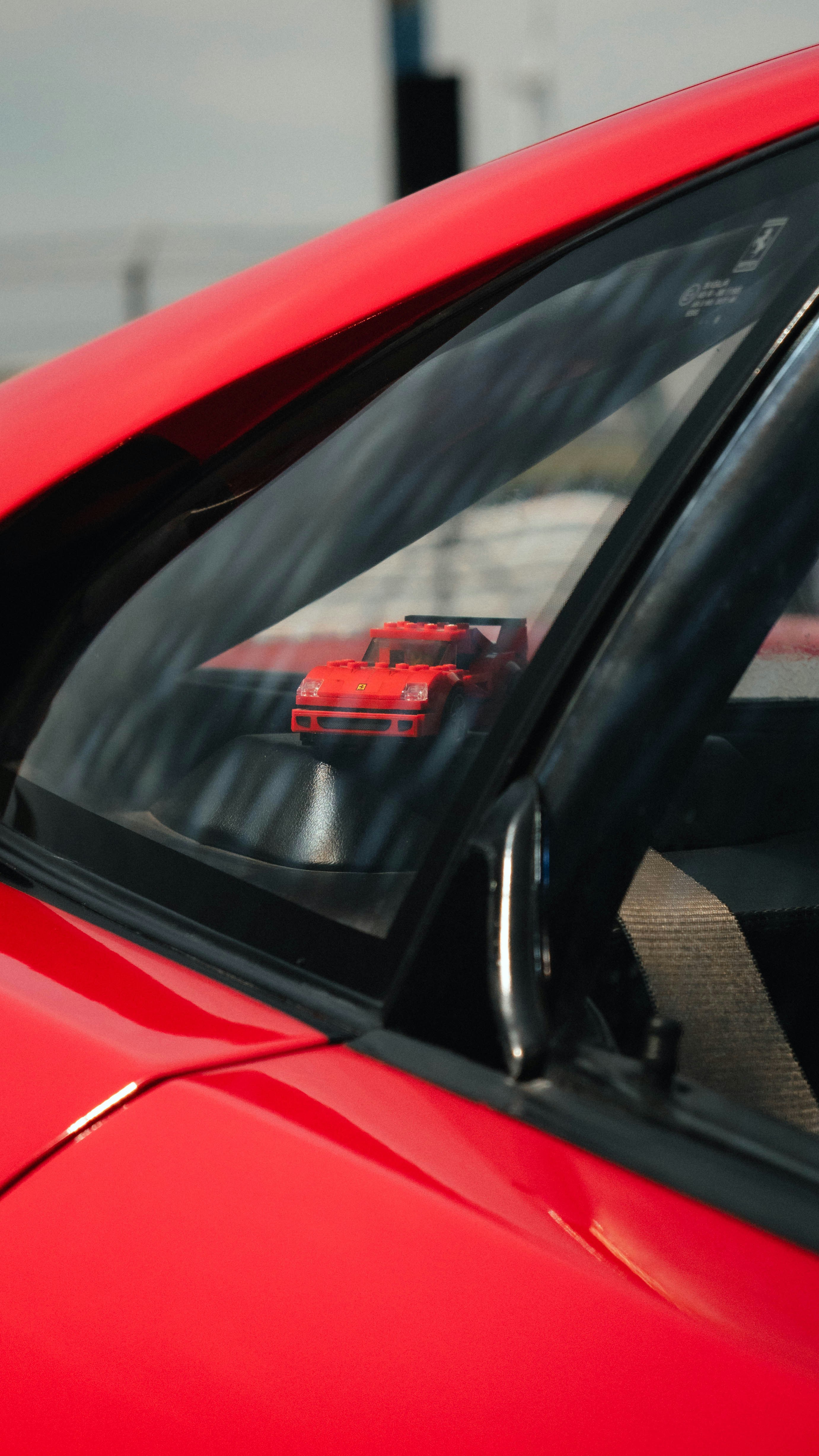 Reflected Rival: A Red Miniature in the Car Window