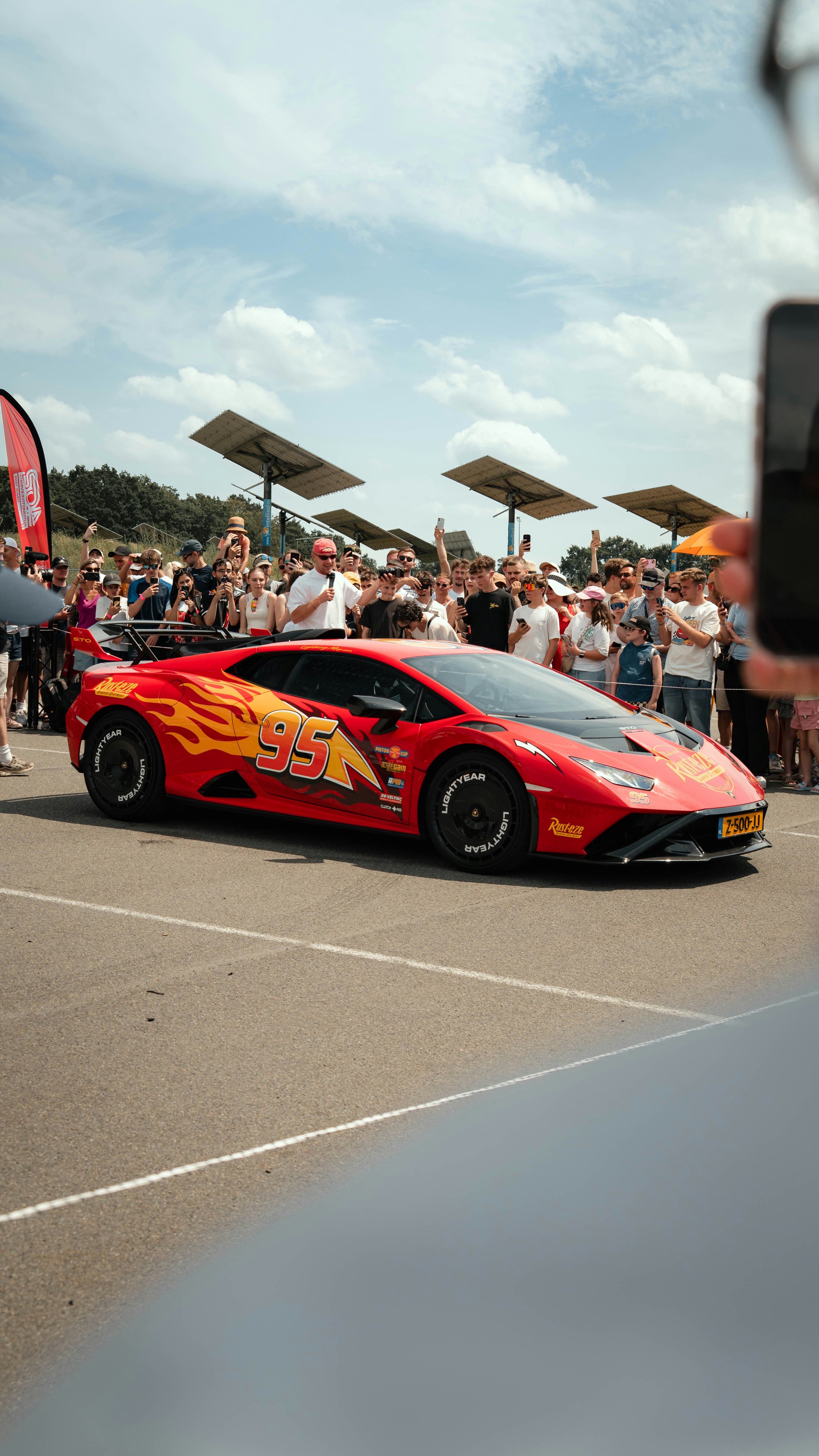Flame‑painted speed, crowd‑lined spectacle