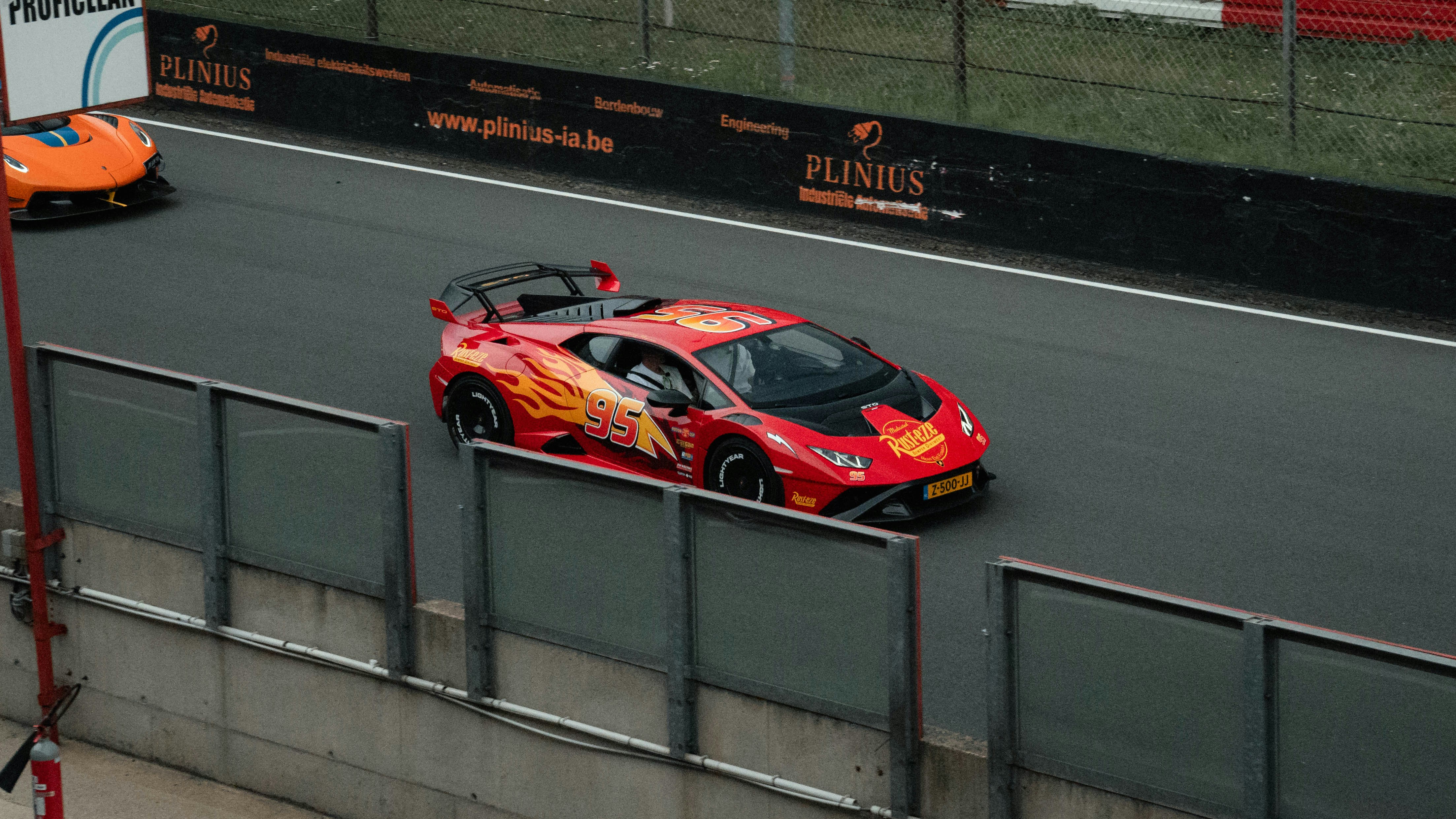 Chrome-on-Track: Red race car slices through the wet tarmac