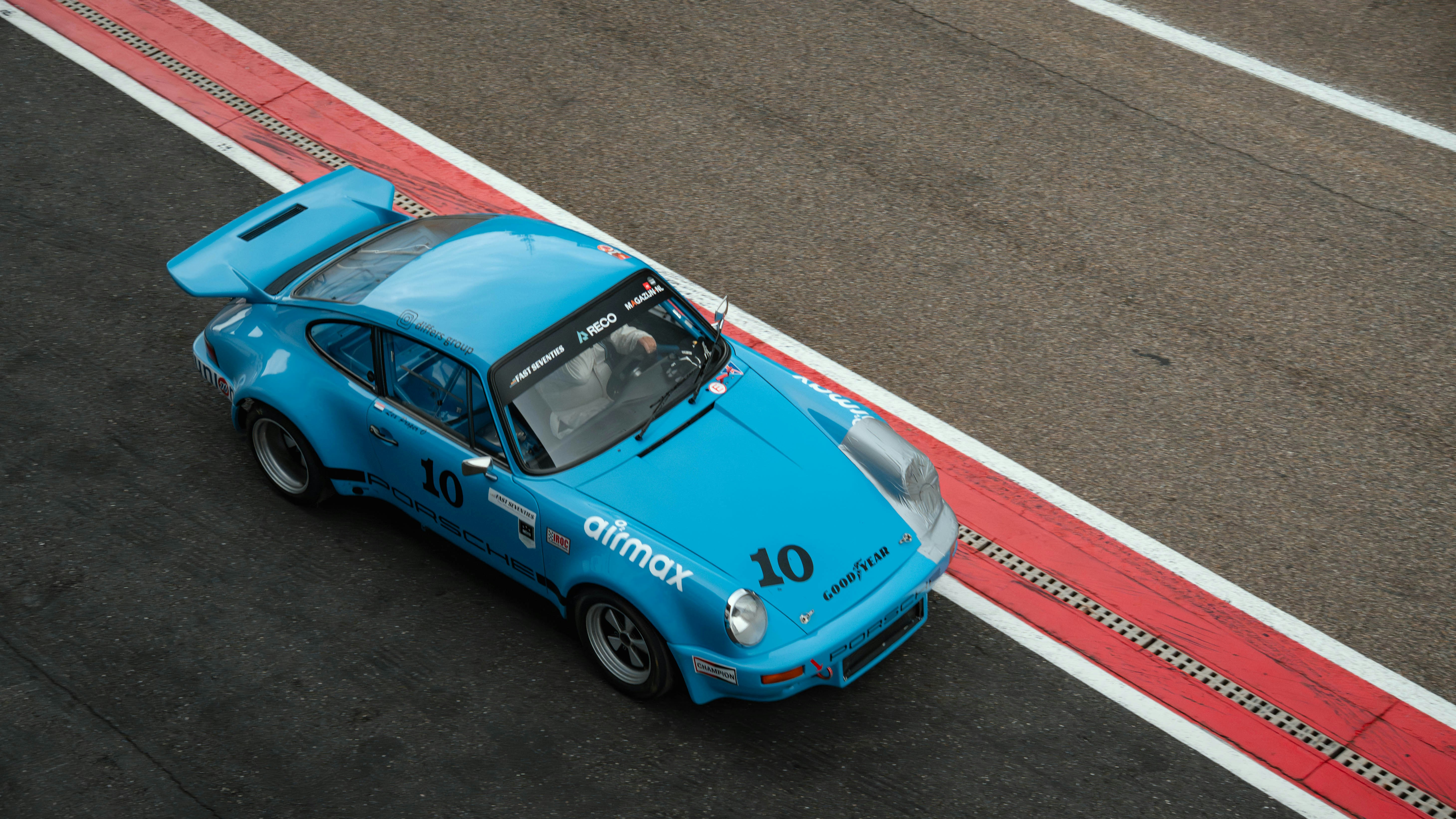 Blue Race Bird: Aerial View of a Vintage Porsche 911 on Pit Lane