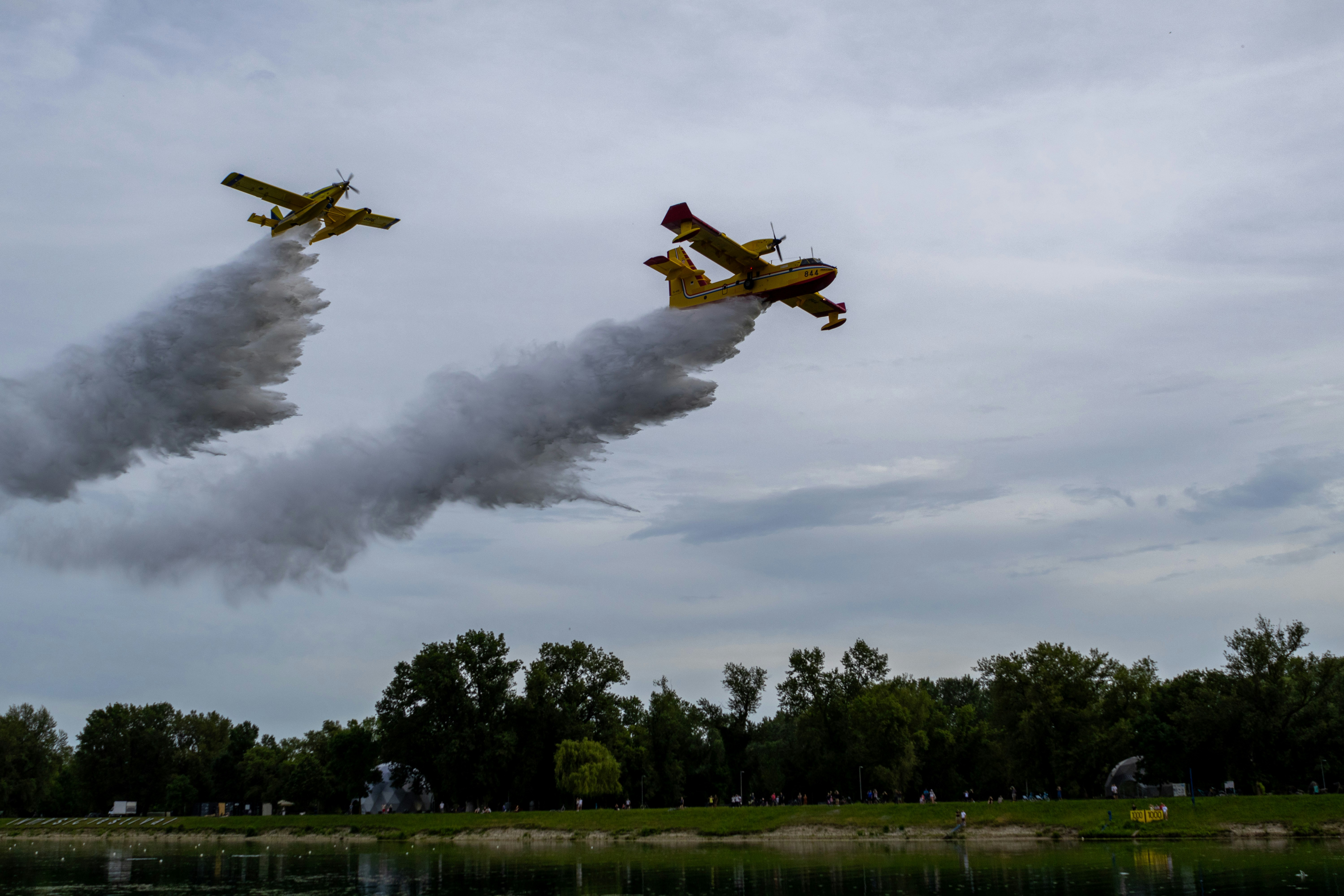 Twin Yellow Wings Ascend: Aerial Smoke Trails Over the Park