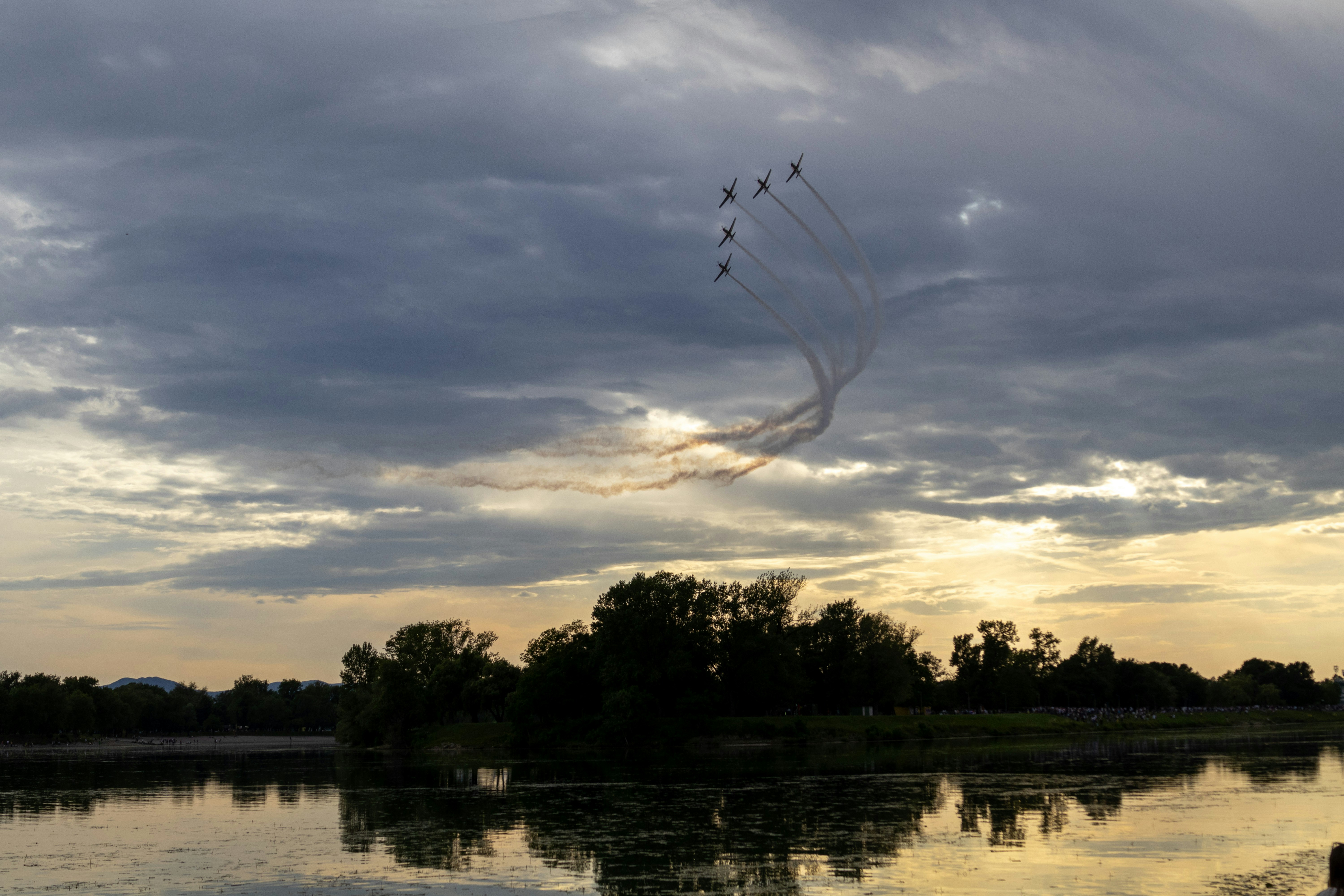 Skyward Echo: Formation of Aircraft Streaks over Calm Lake