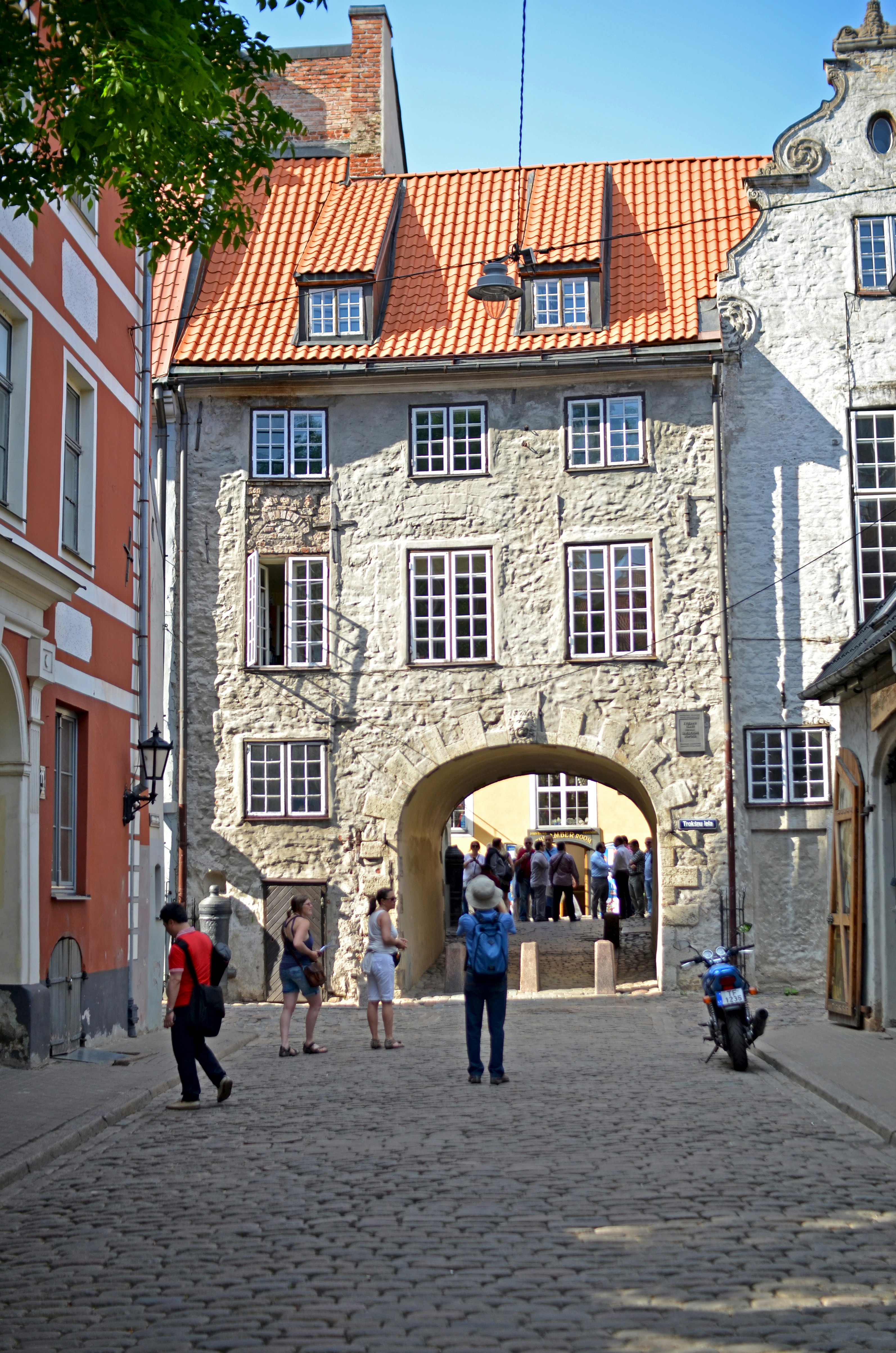 Arched Passageway Through Sunlit Stone Facade