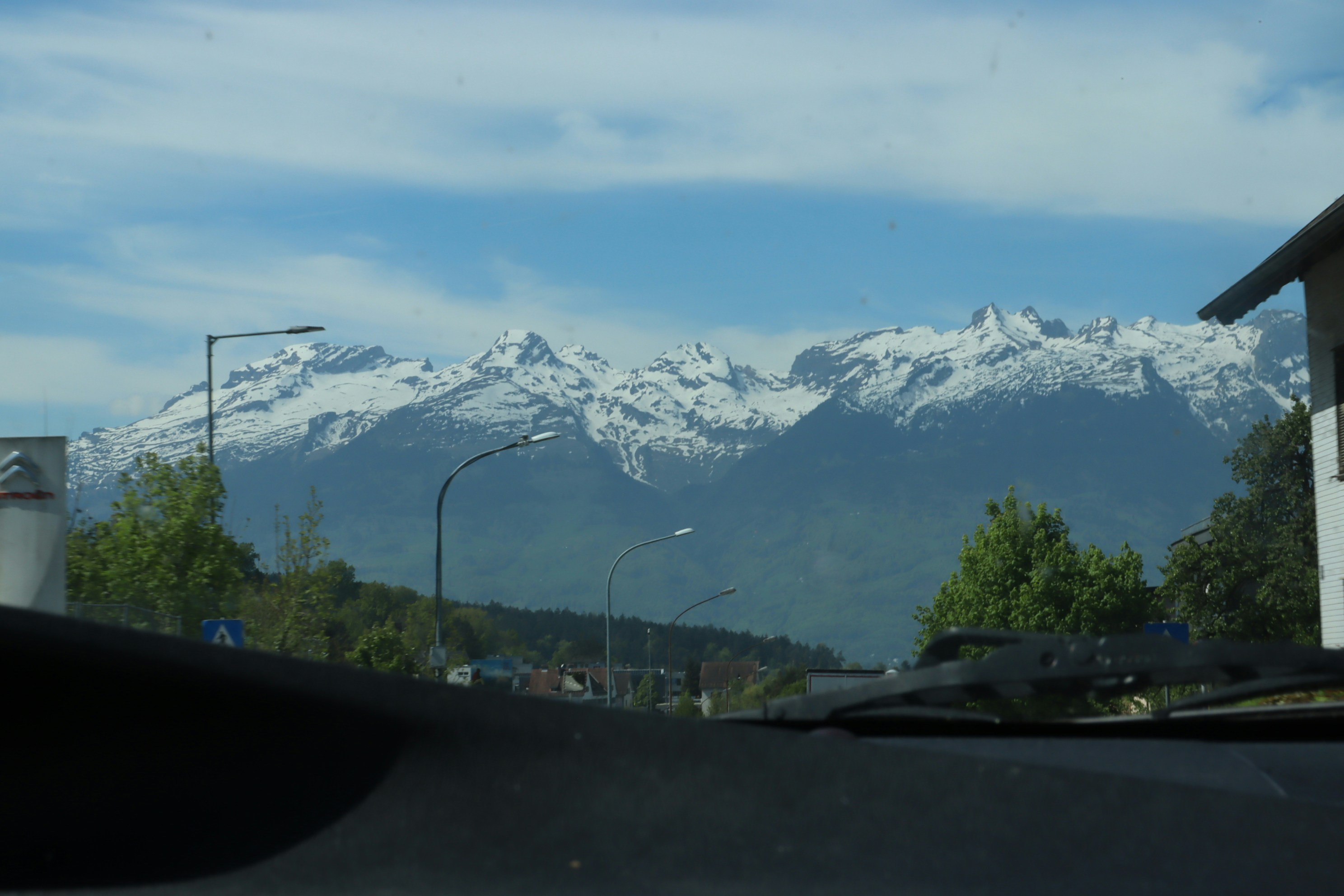Snow-capped Alps beyond a Car Dashboard