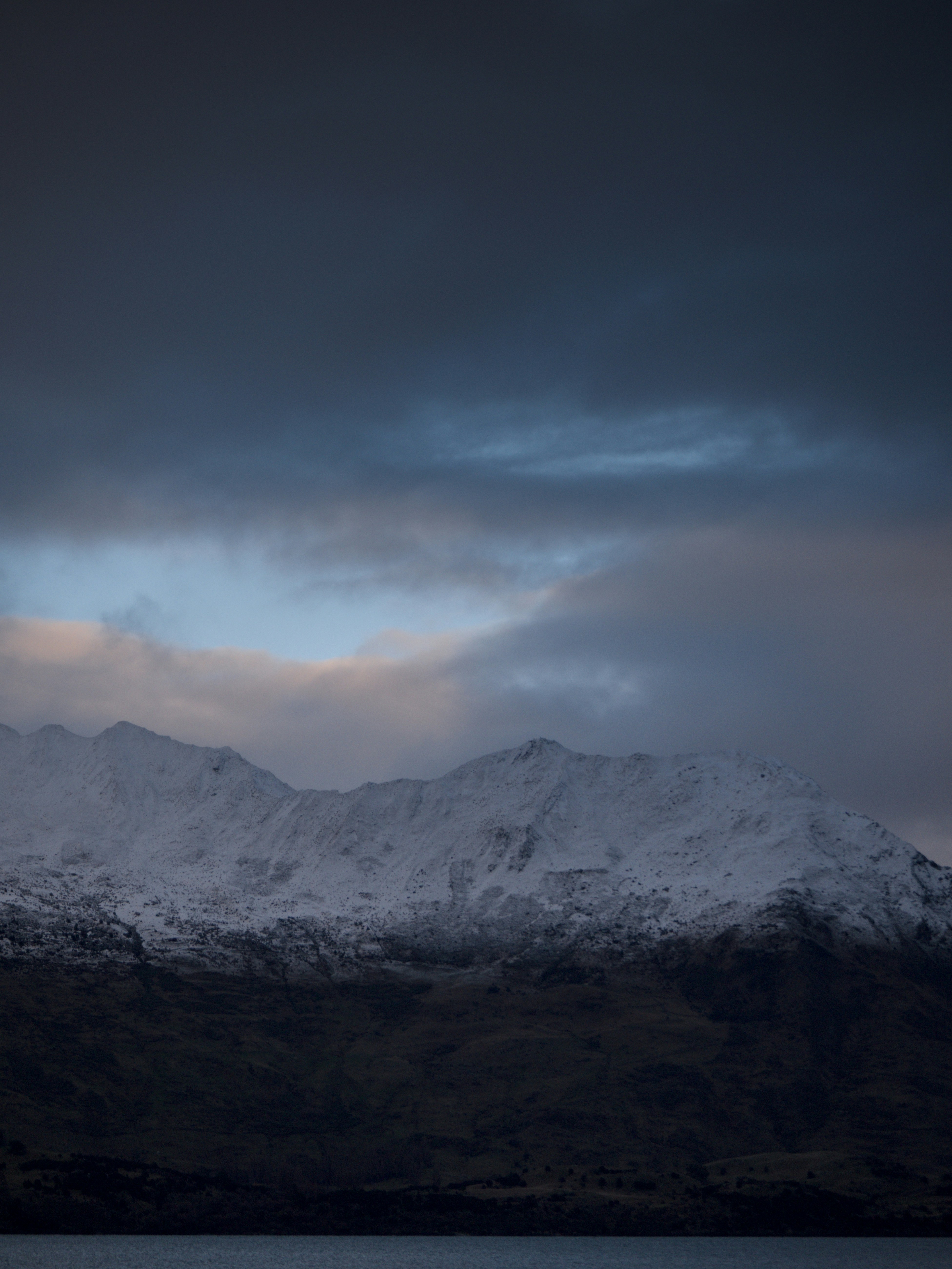 Snow-kissed Horizon: A Quiet Ridge Beneath Crimson Clouds