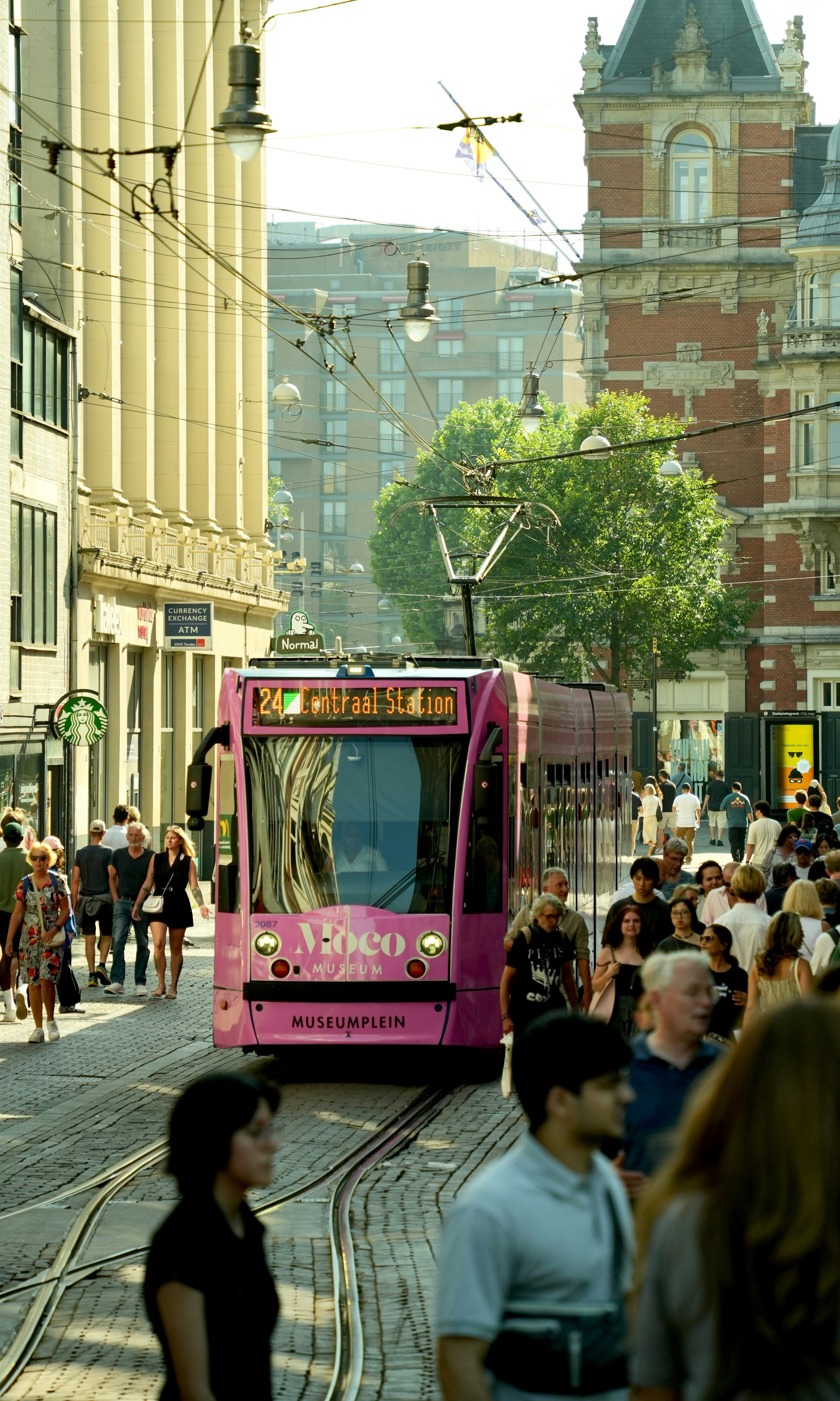 Pink Tram in a Bustling European Street
