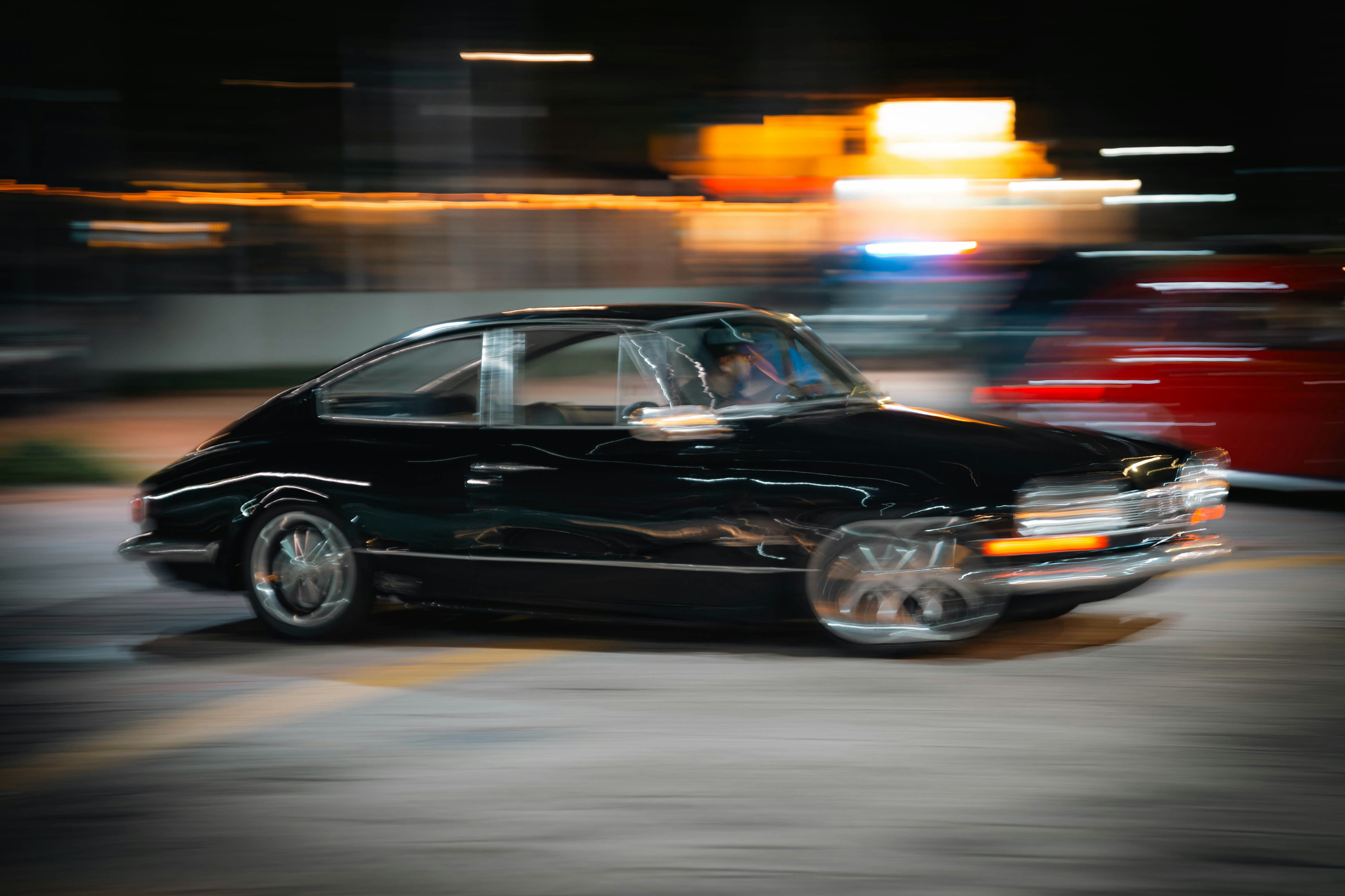 Midnight Rally: a black vintage coupe blazing through neon night