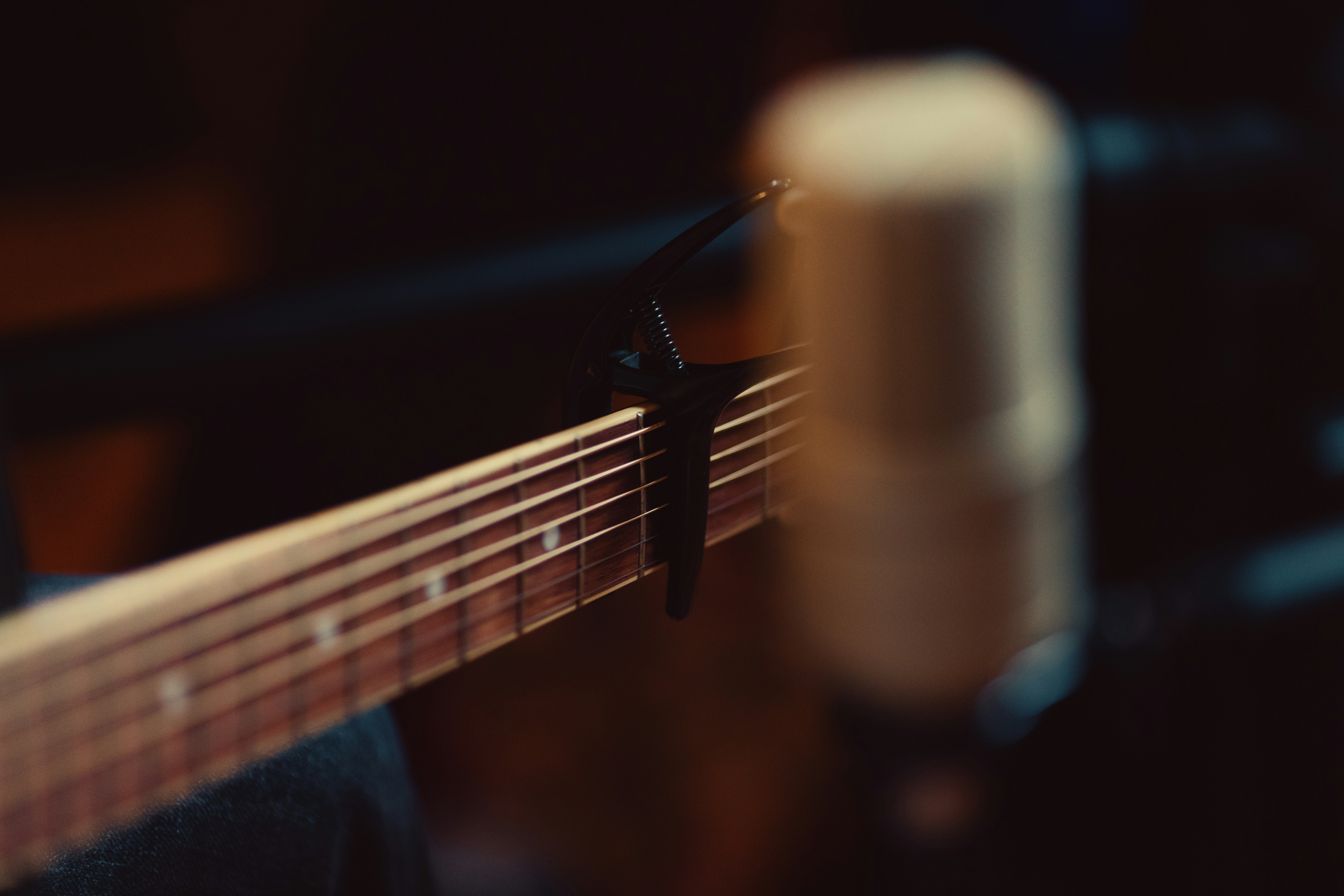 Mic in the Spotlight: A Close-Up of Guitar and Microphone in Low Light
