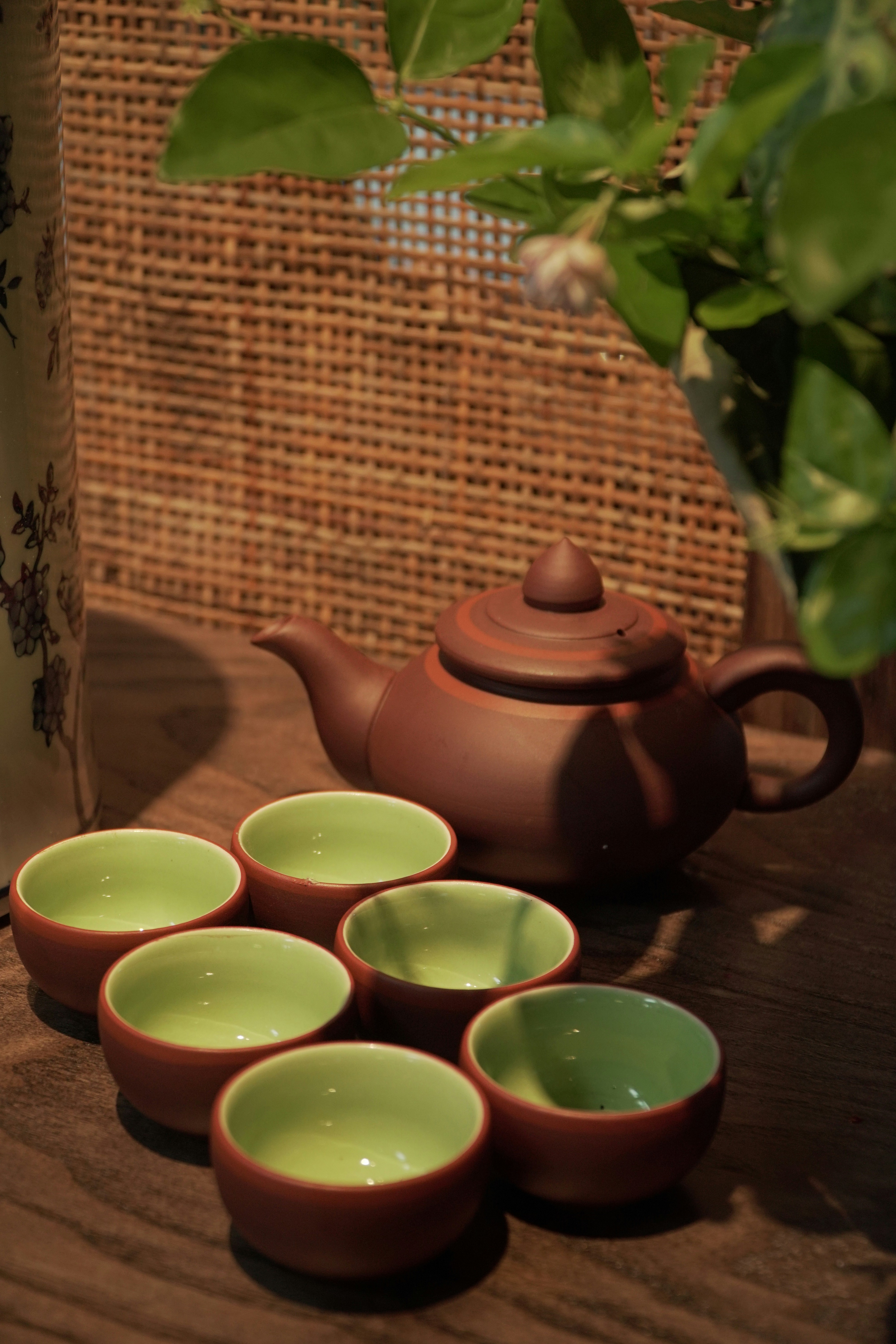 Warm Tea Still Life: Clay Teapot and Six Cups on a Wooden Table