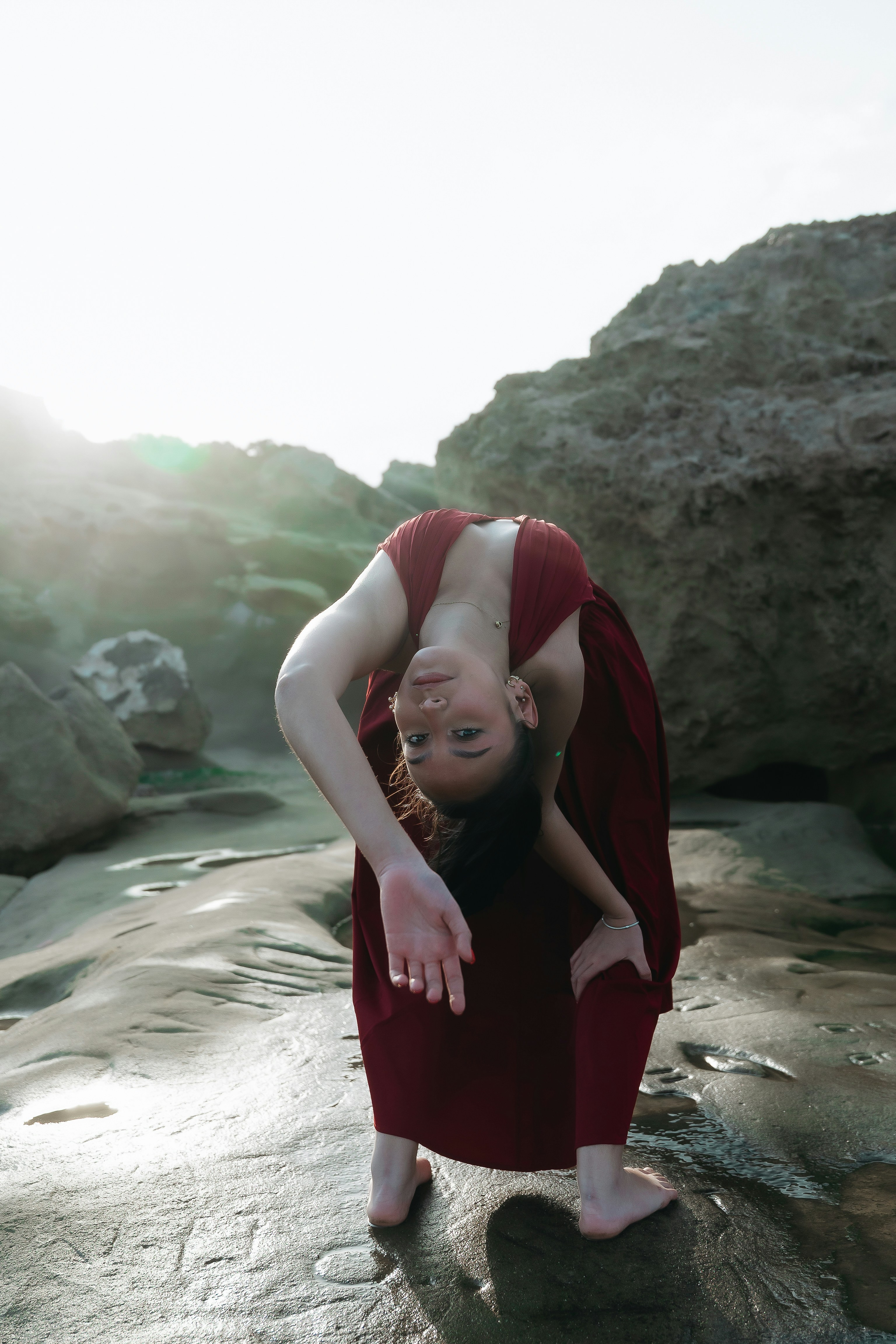 Red-draped Grace: An Inverted Pose Against Seaside Clifflight