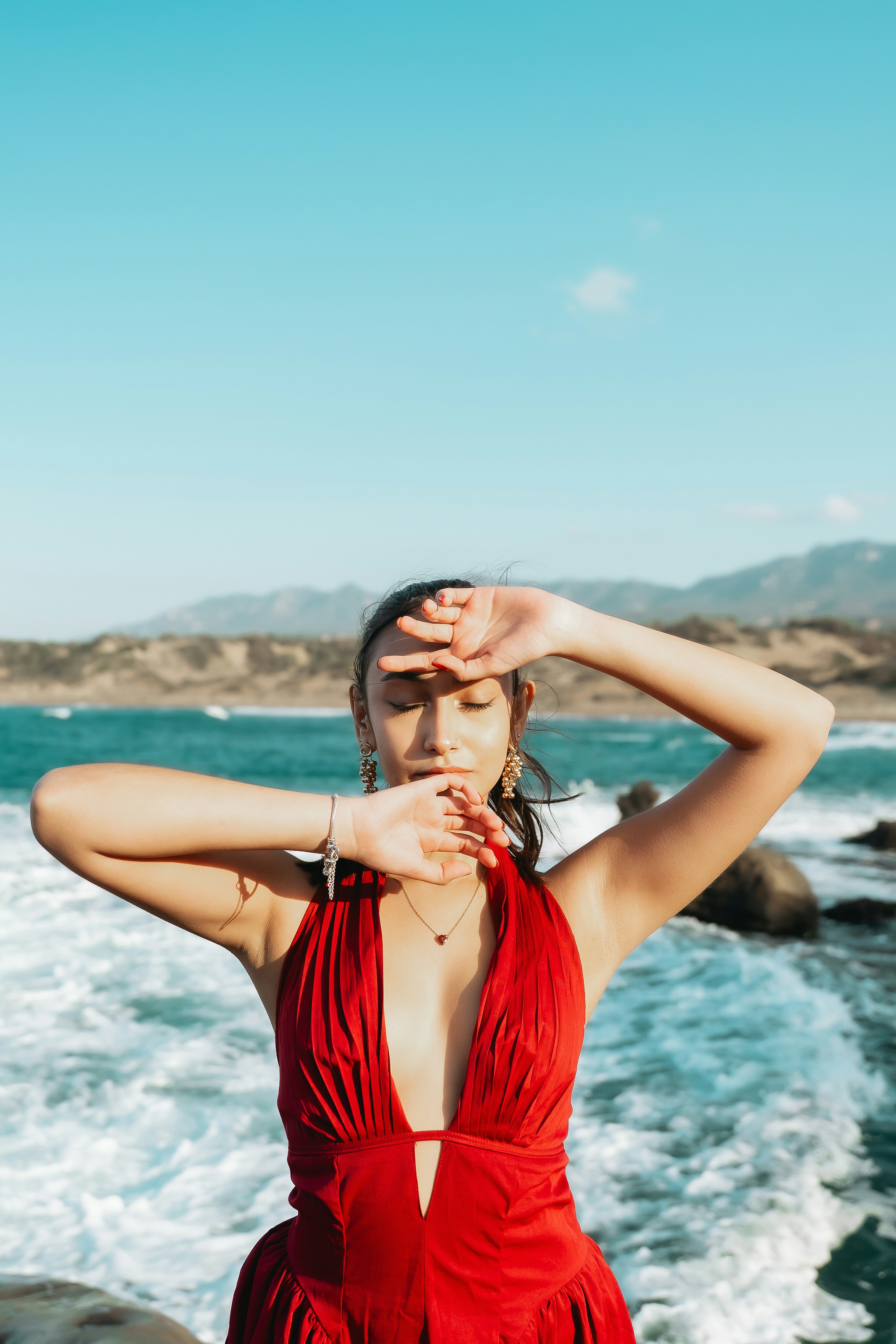 Crimson Dress at the Sea: A Moment of Shade and Sun