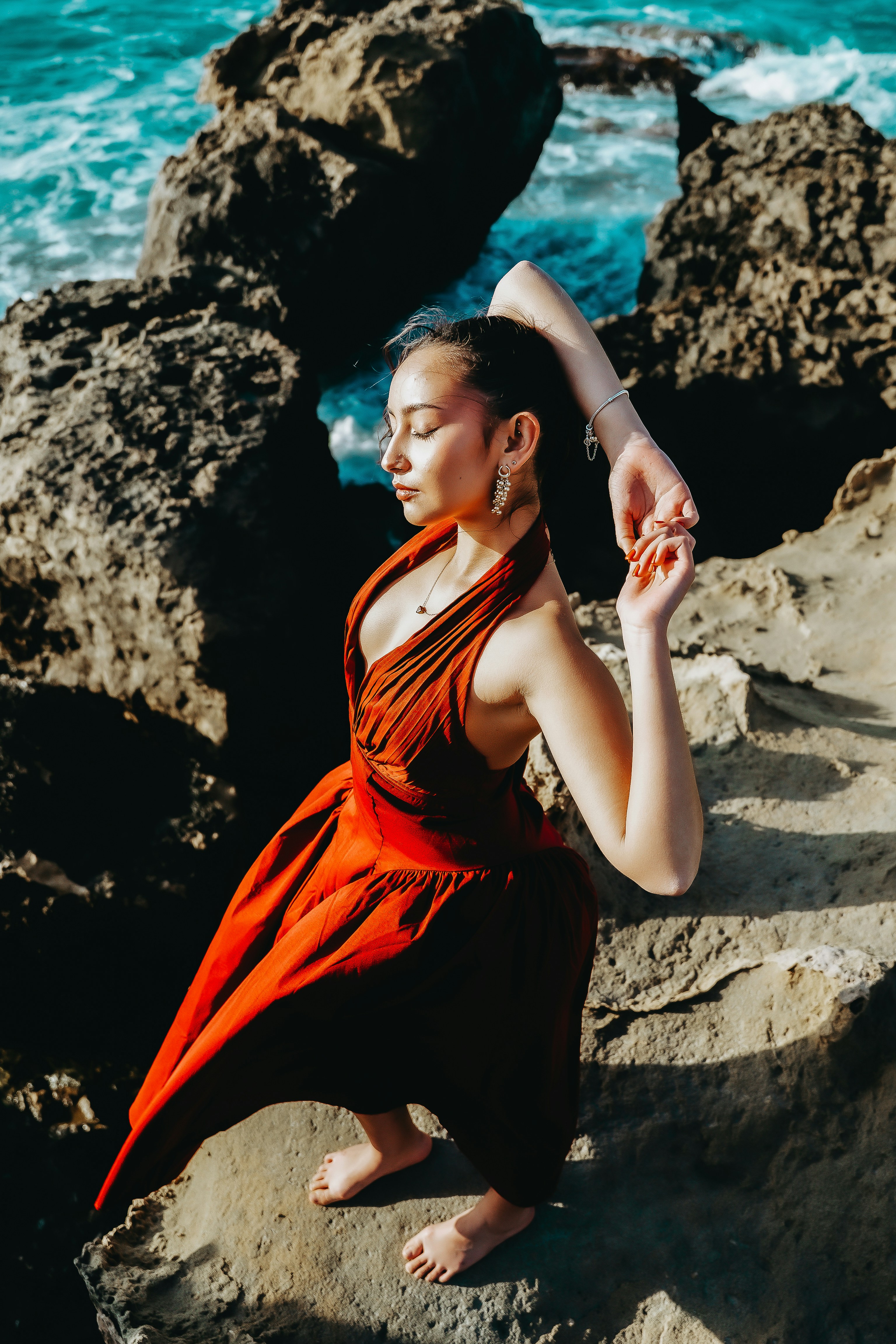 Crimson Silk on Limestone: A Poised Portrait by the Sea