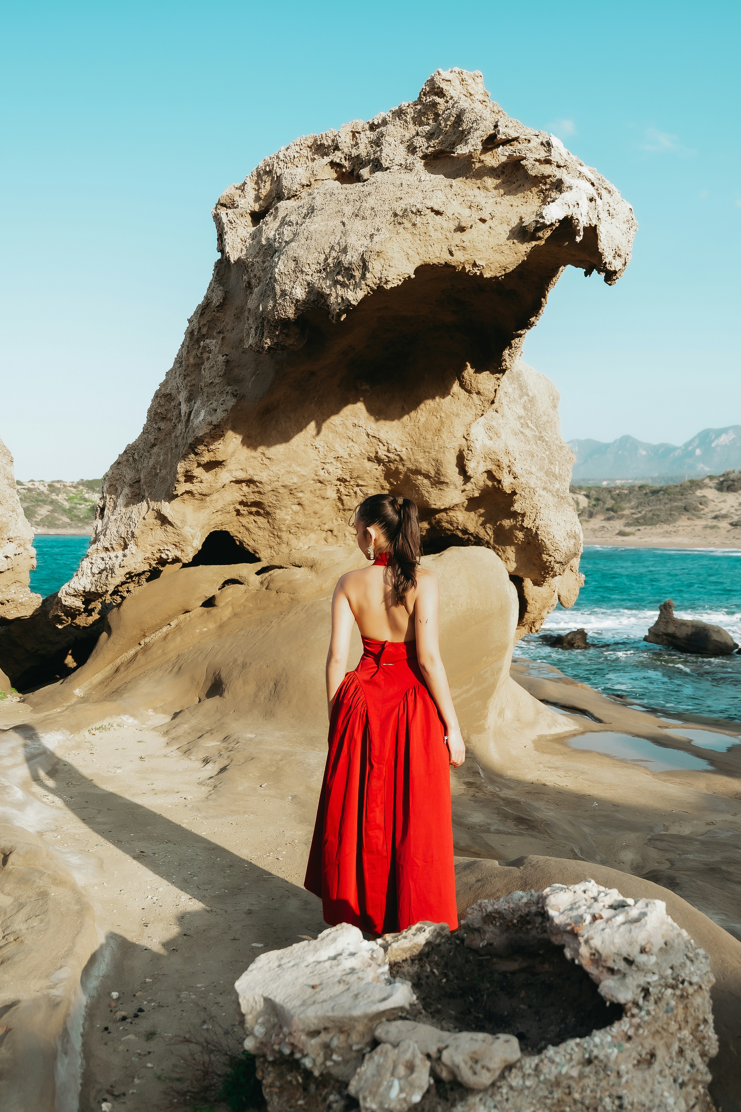 Red-dressed silhouette at the tidal rock arch