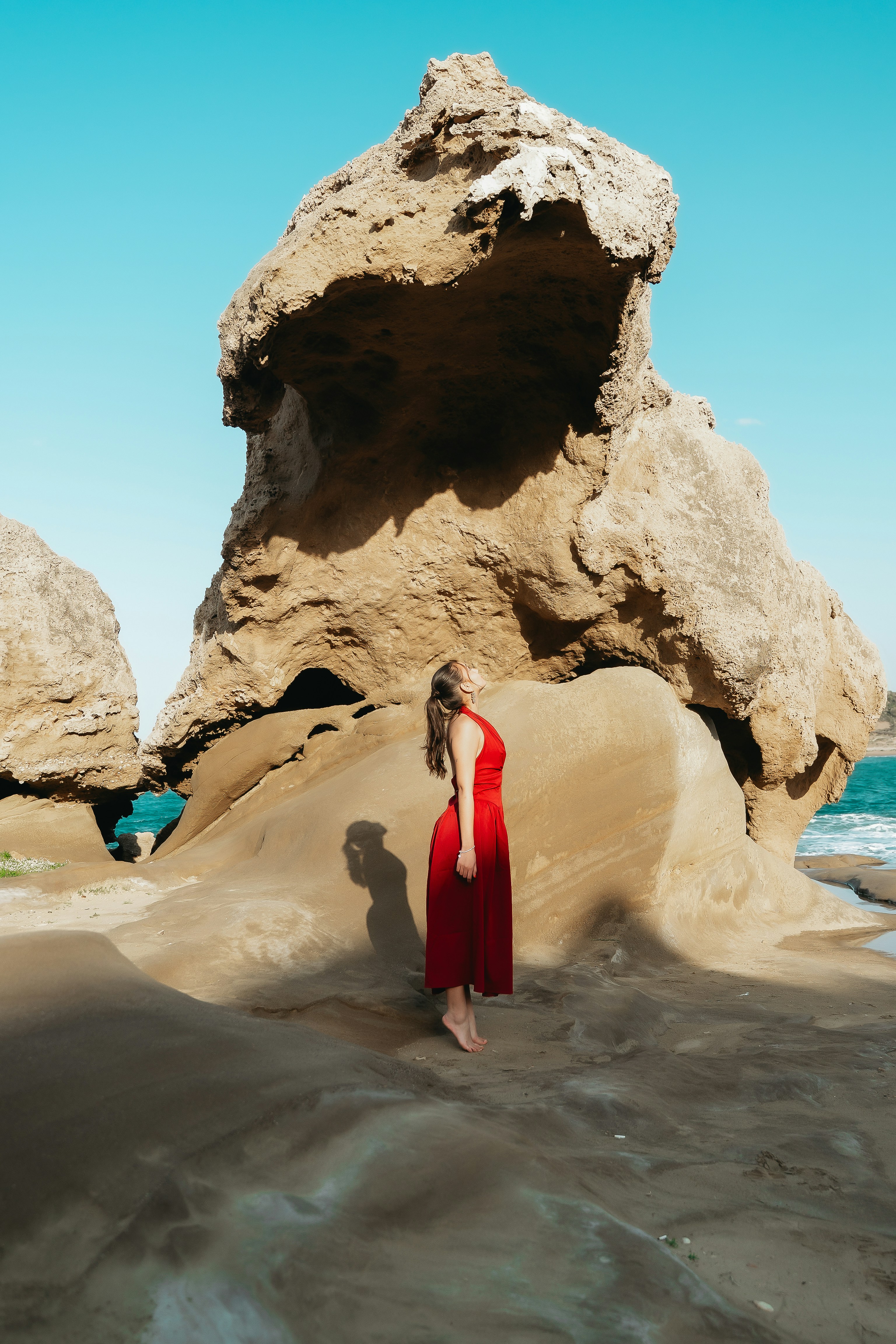 Red dress at the sea-worn arch