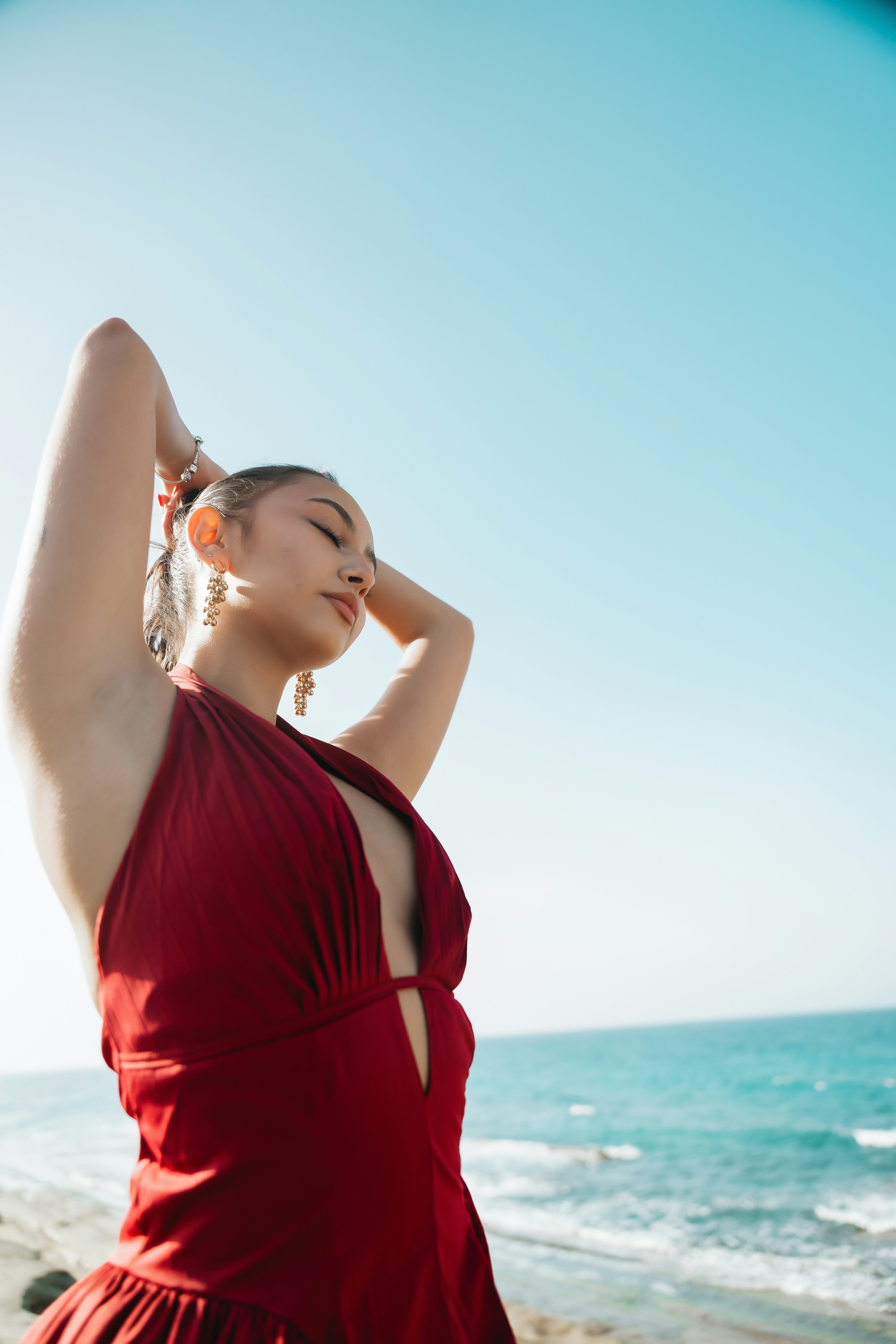 Red Velvet by the Sea: A Portrait of Poise Against the Ocean Grasp