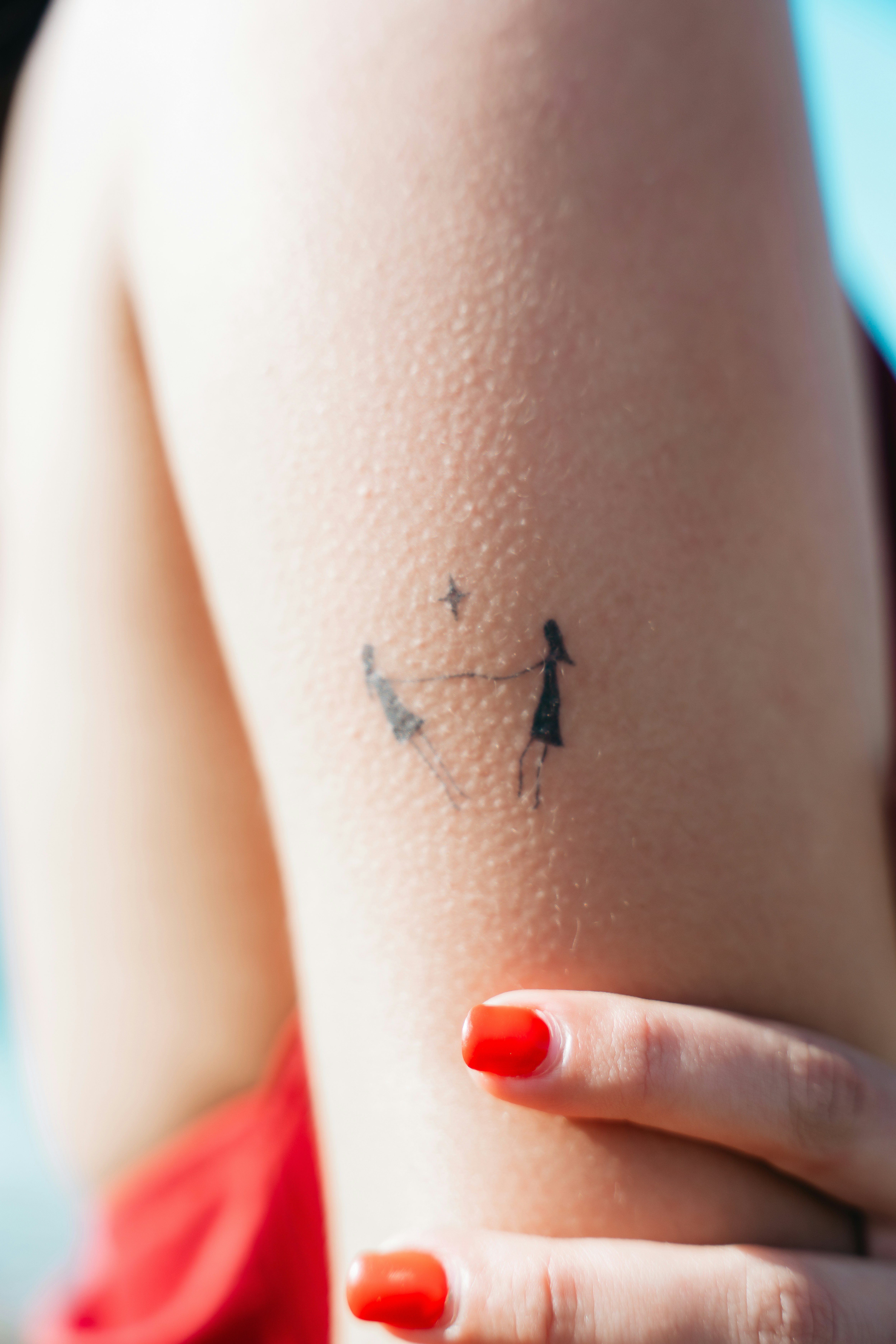 Minimalist tattoo sketch on sunlit forearm