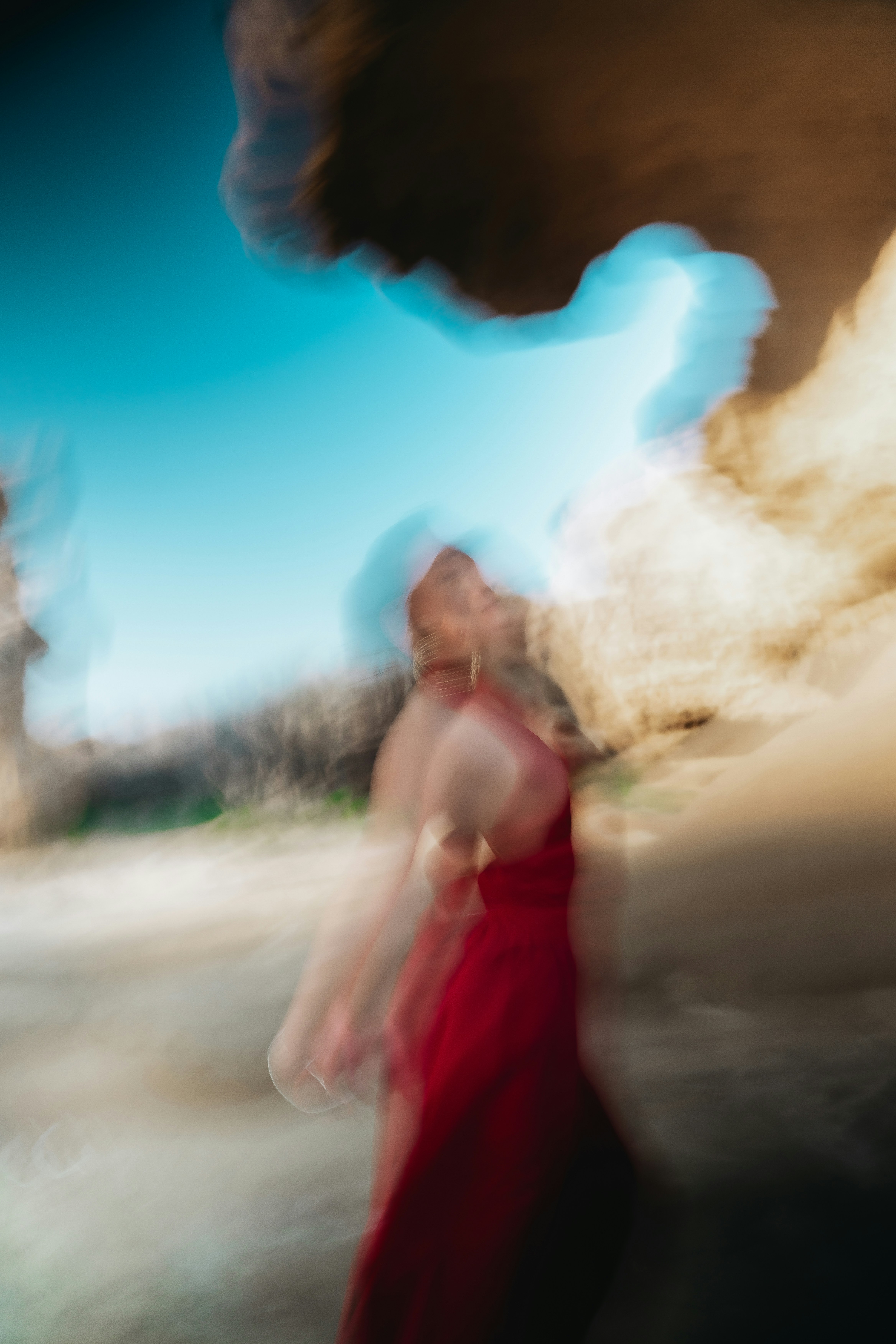 Blurred Echo: A Red Dress in a Dreamlike Desert Canyon