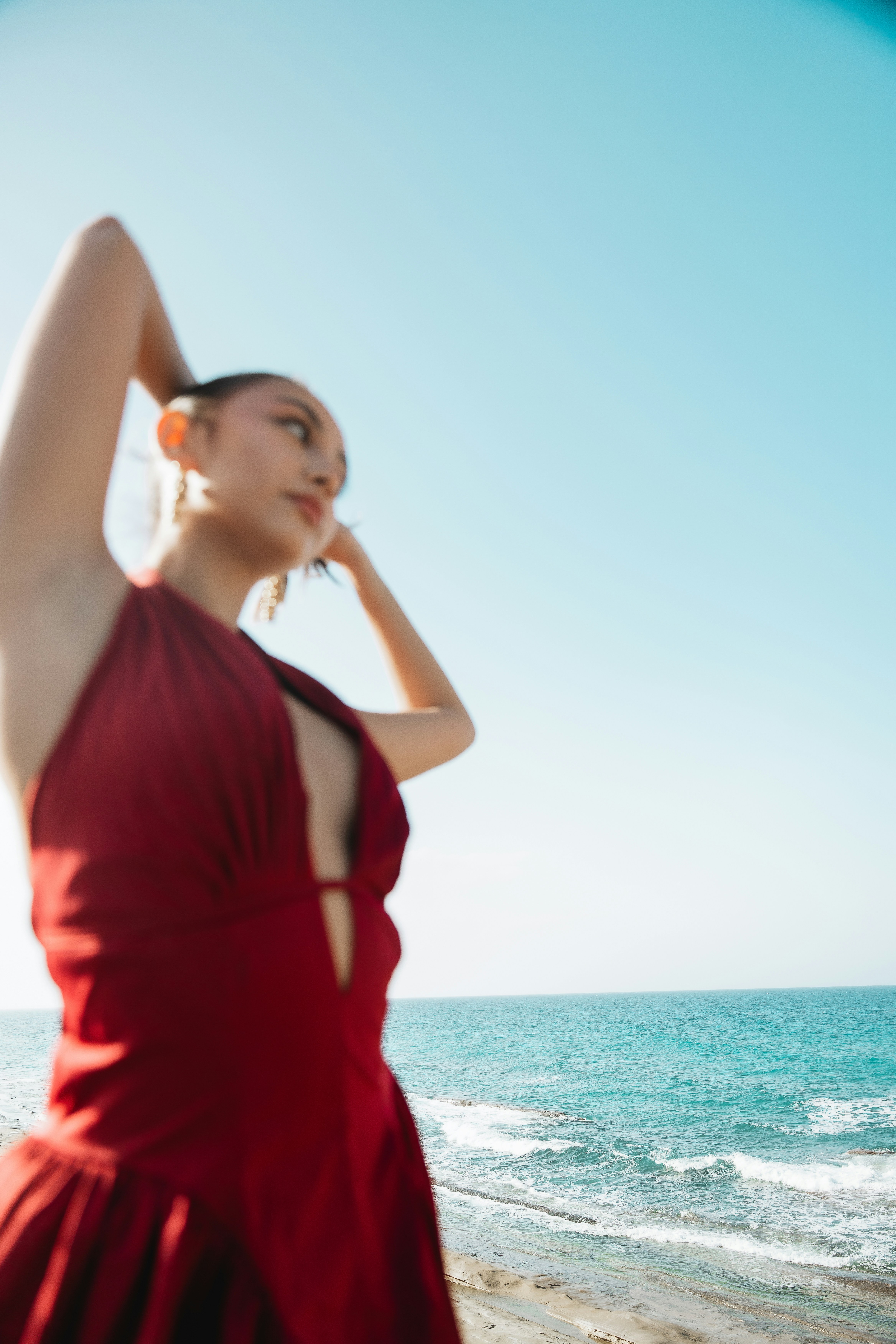 Red Glow by the Sea: A Blurred Pose Against A Clear Horizon