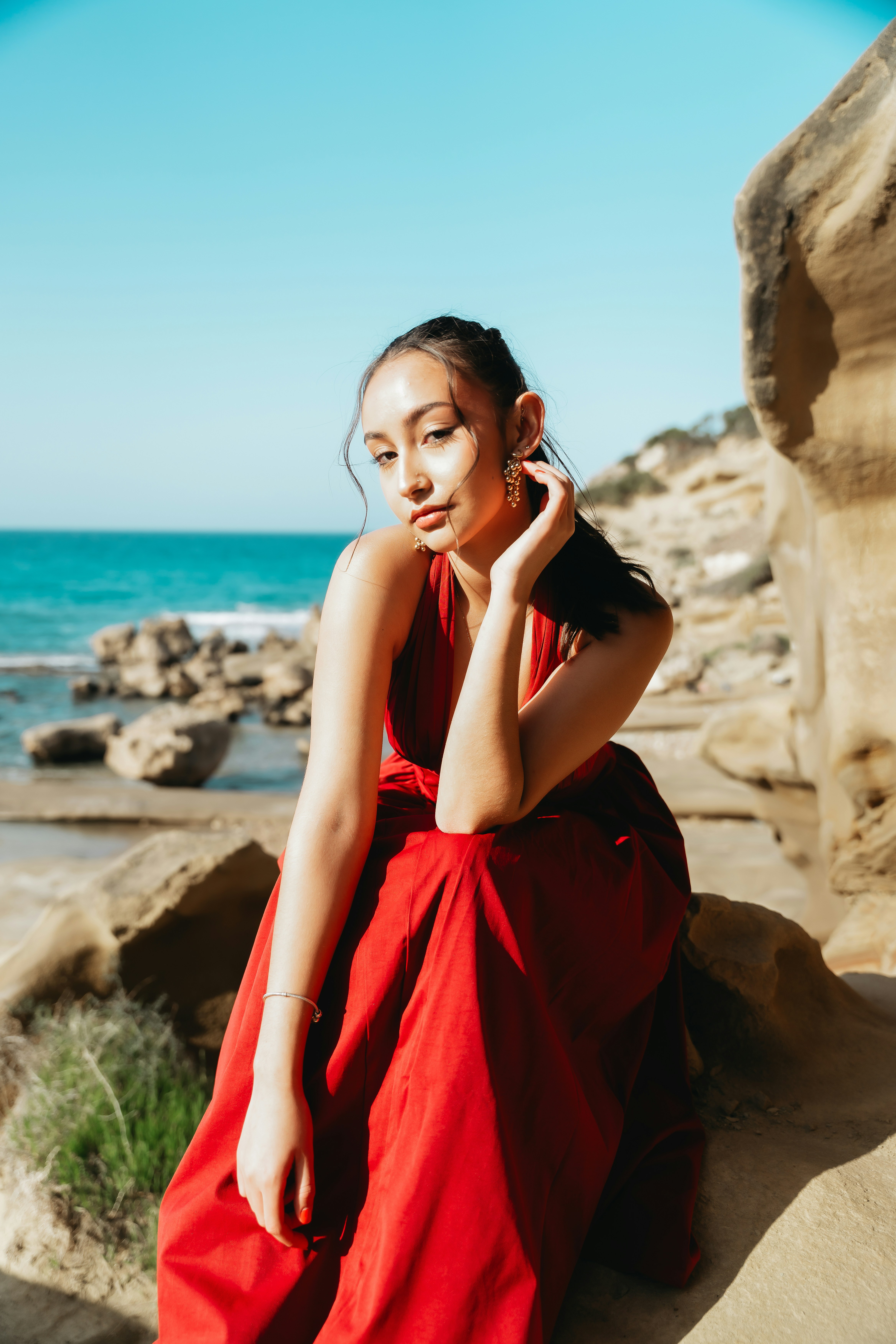 Red Dress, Ocean Backdrop: A Quiet Pose by the Cliff