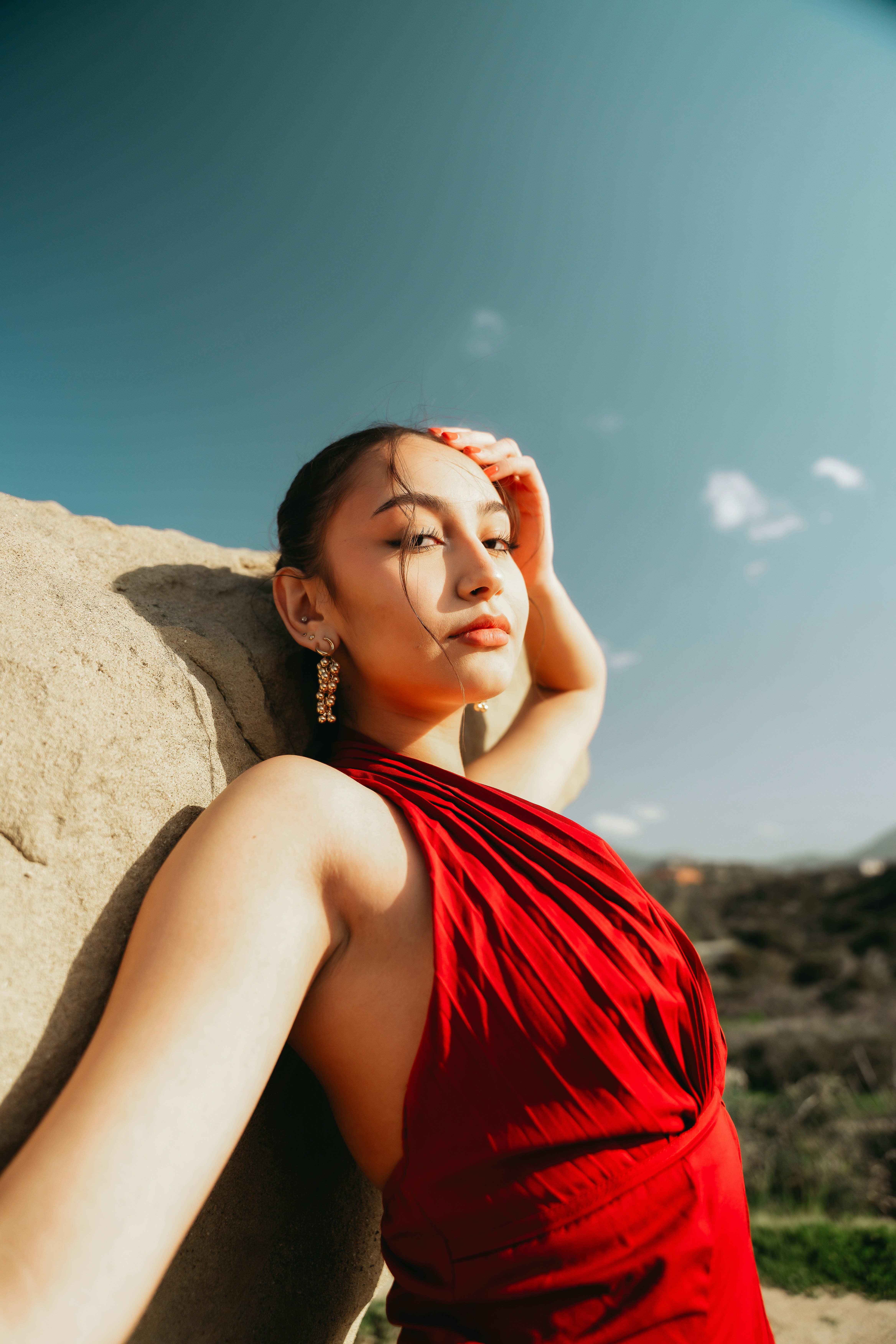 Crimson Draped Gaze Against Sunlit Stone