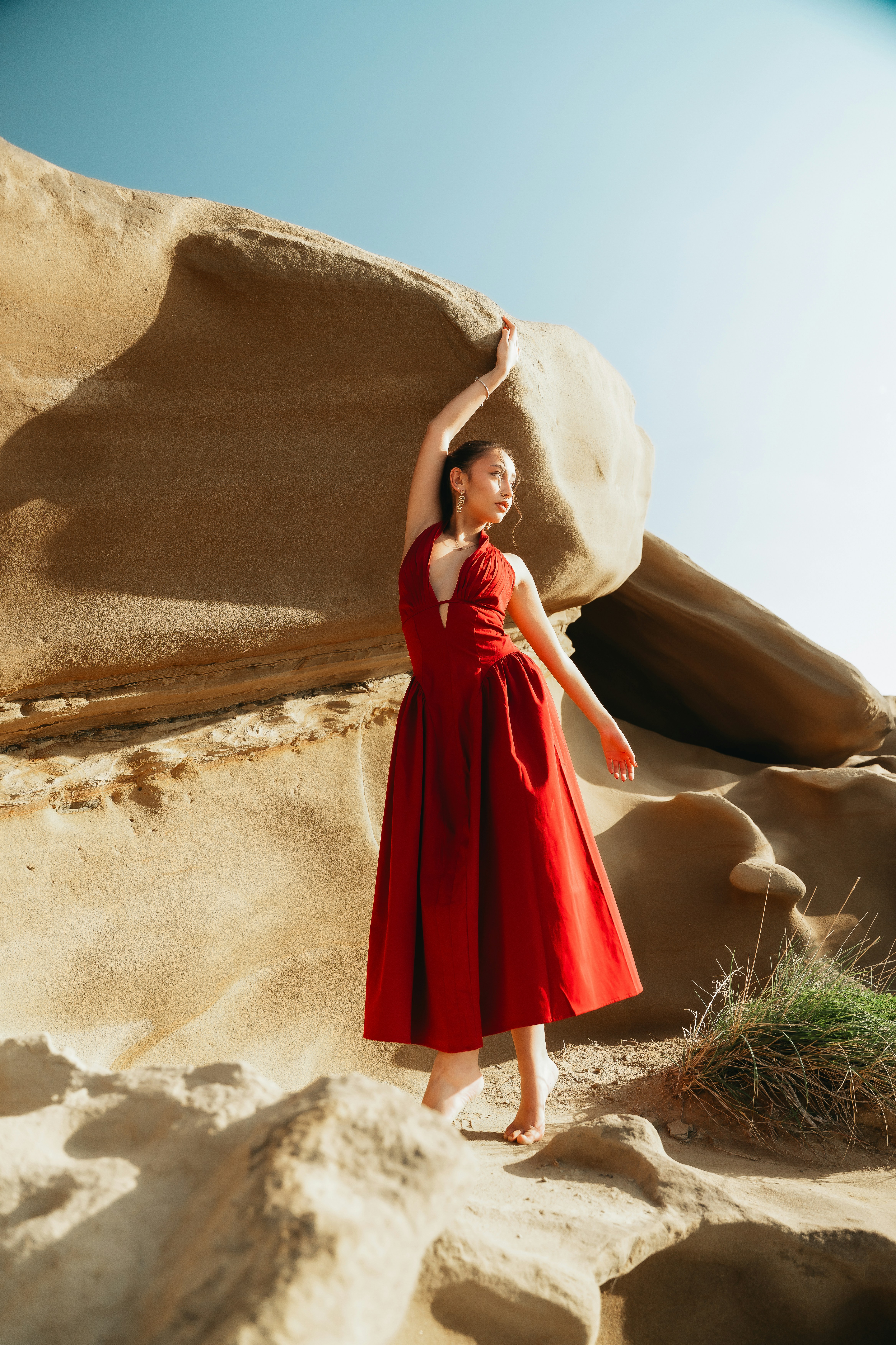 Red-dressed dancer in sunlit desert rock alcove