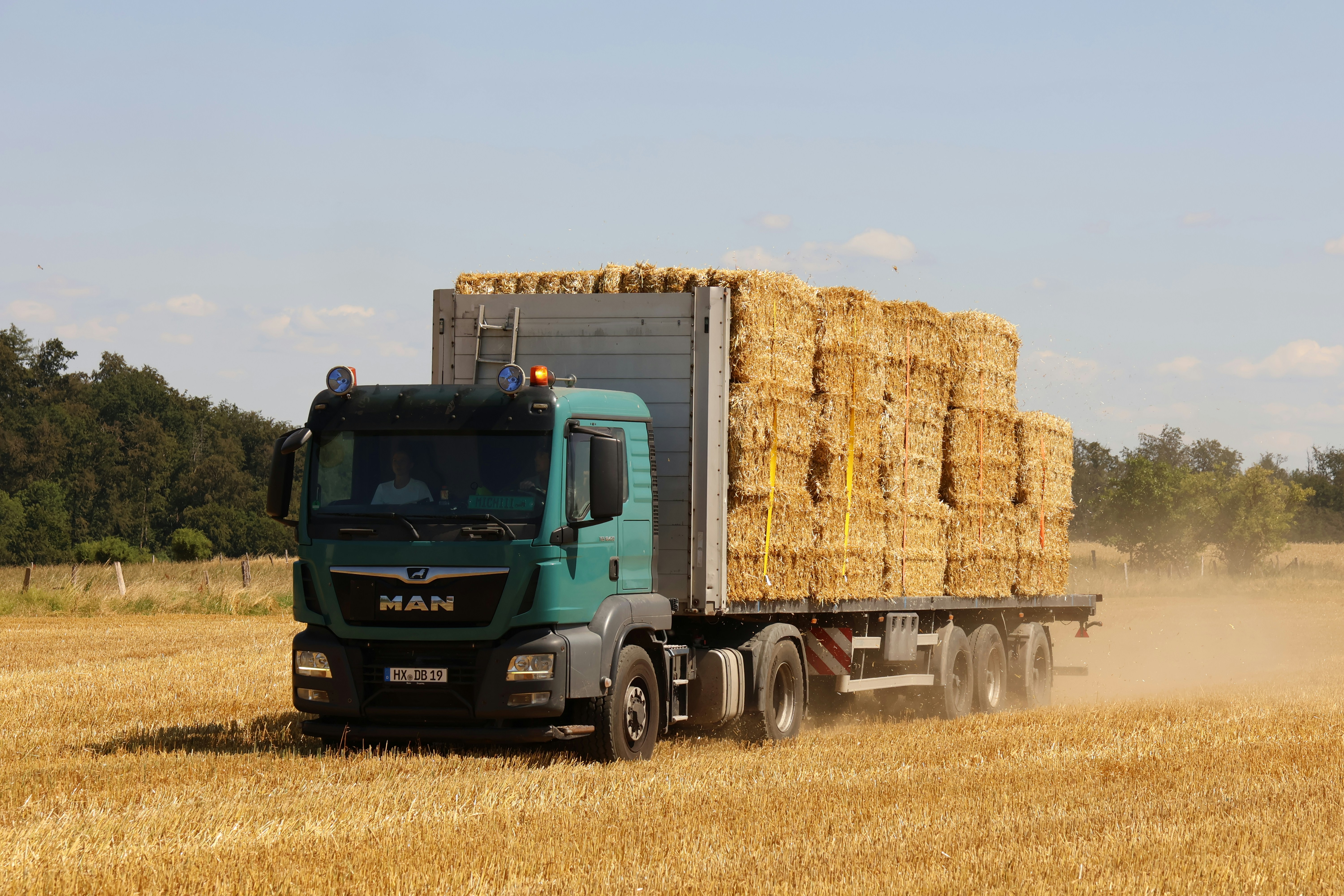 Harvest Hauler: A Green Mover Guiding Bales Across a Dusty Field