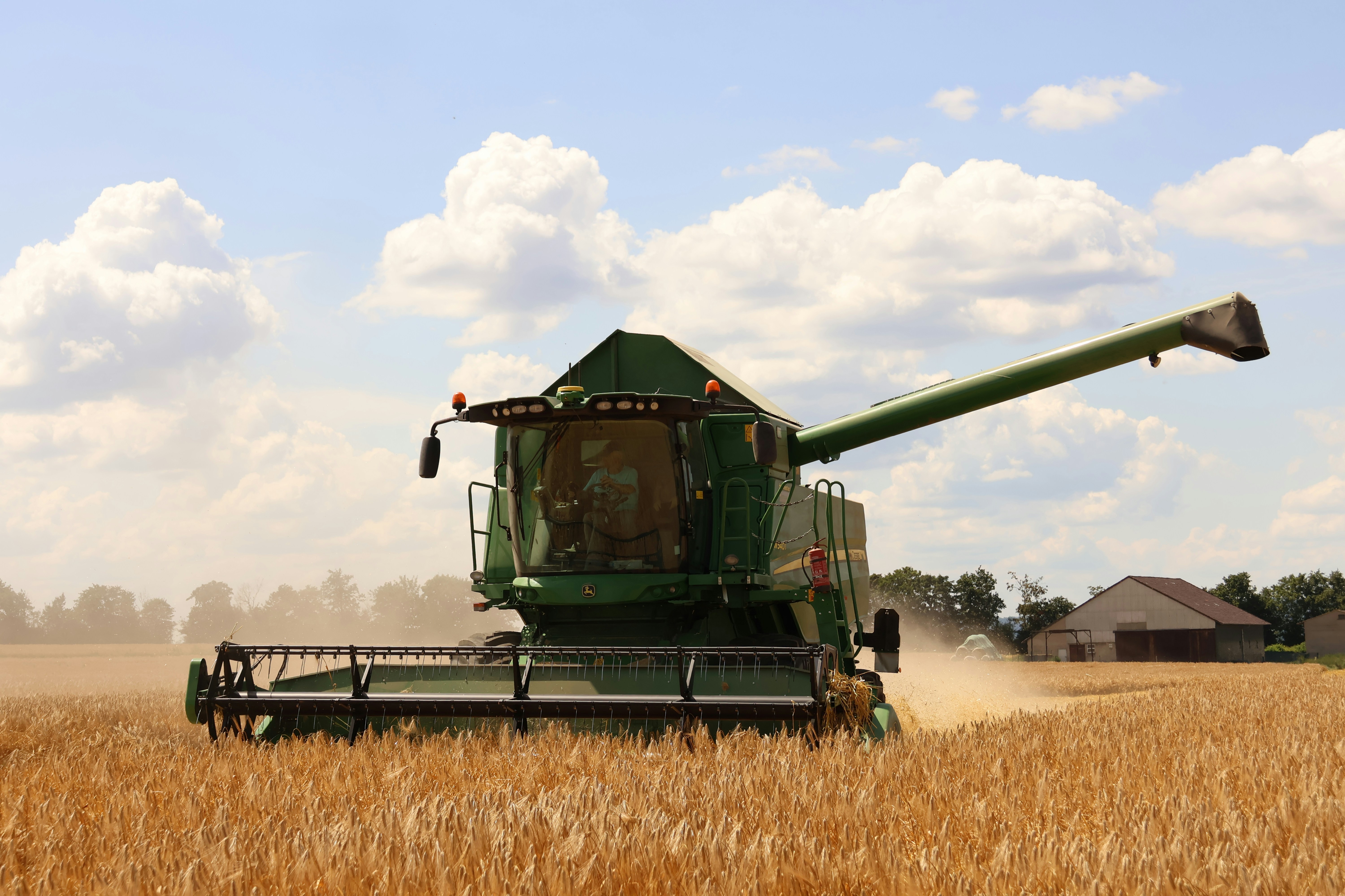 Green Harvester at Dawn: A Harvest Scene in Golden Fields