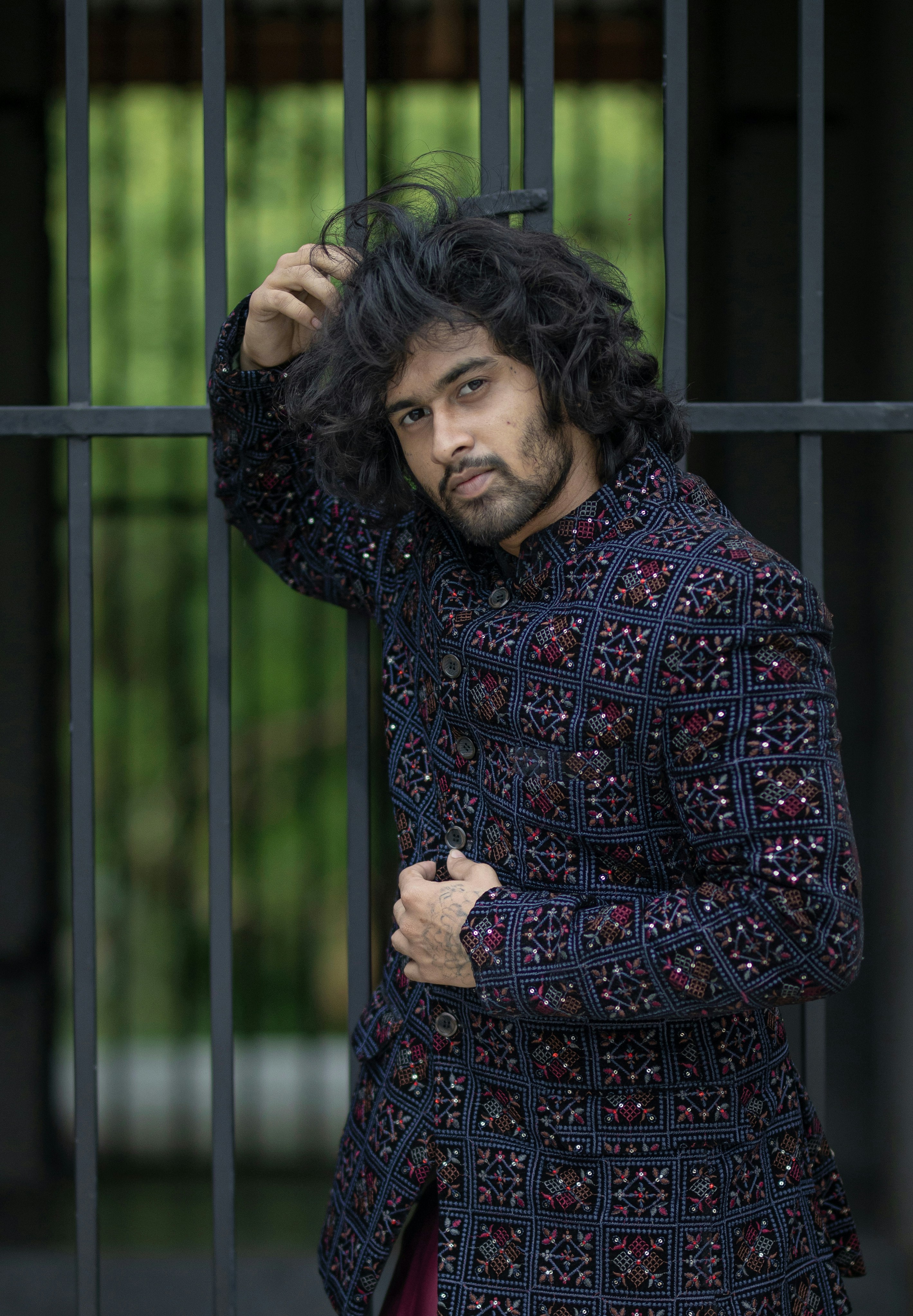 Portrait behind iron bars: a contemplative gaze in patterned attire