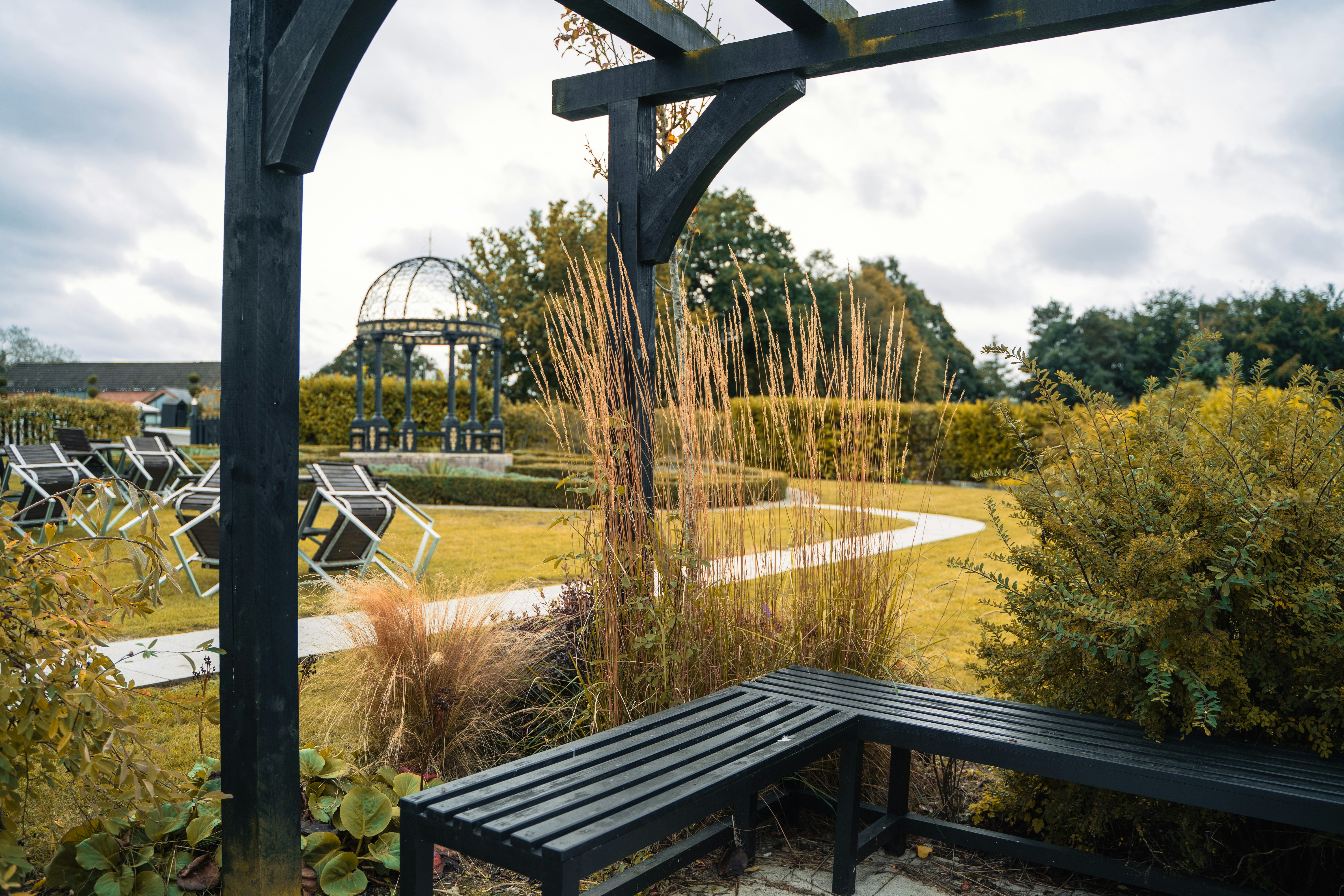 Arched pergola over a serene garden seating area