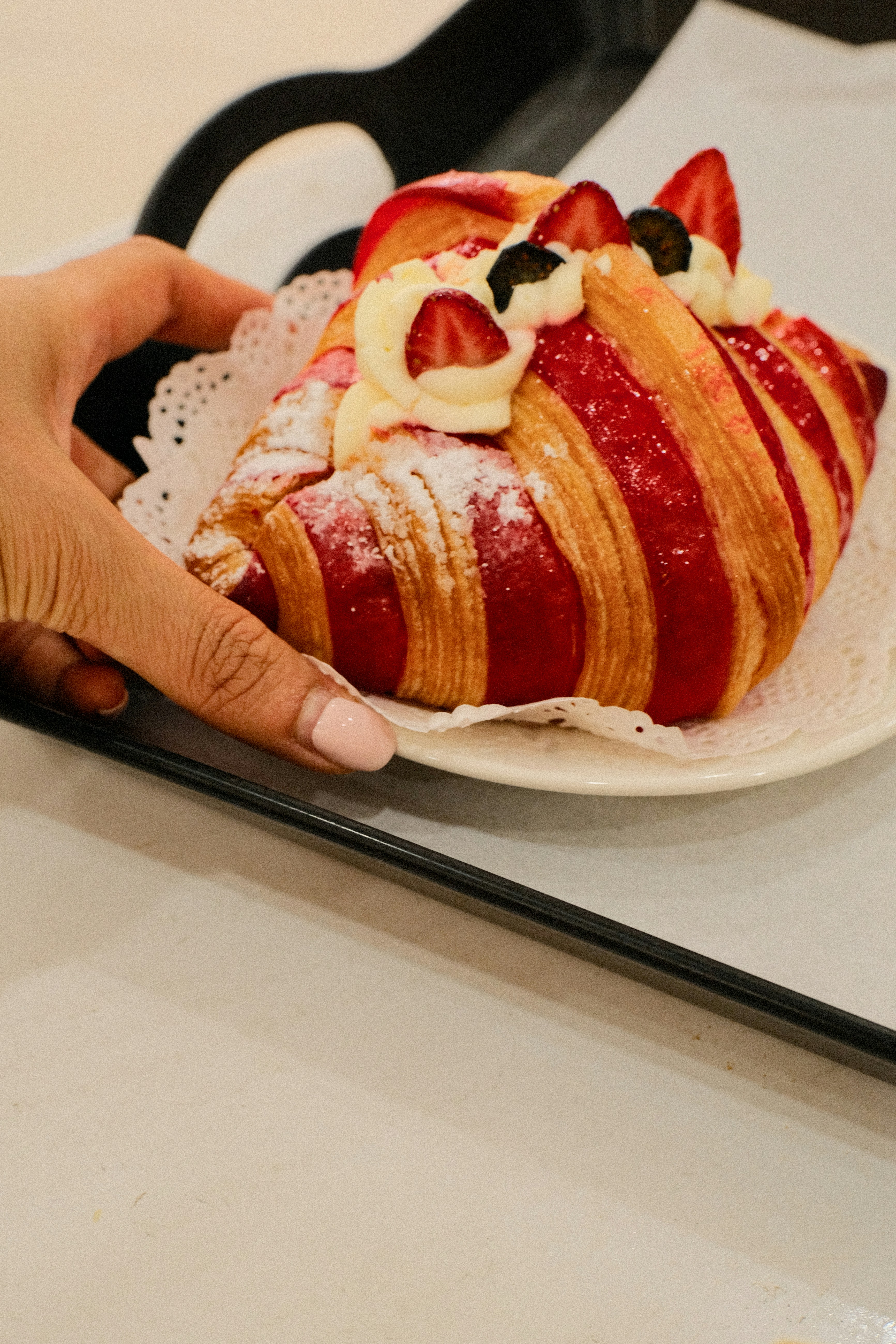 Strawberry-cream pastry on a sleek black serving tray