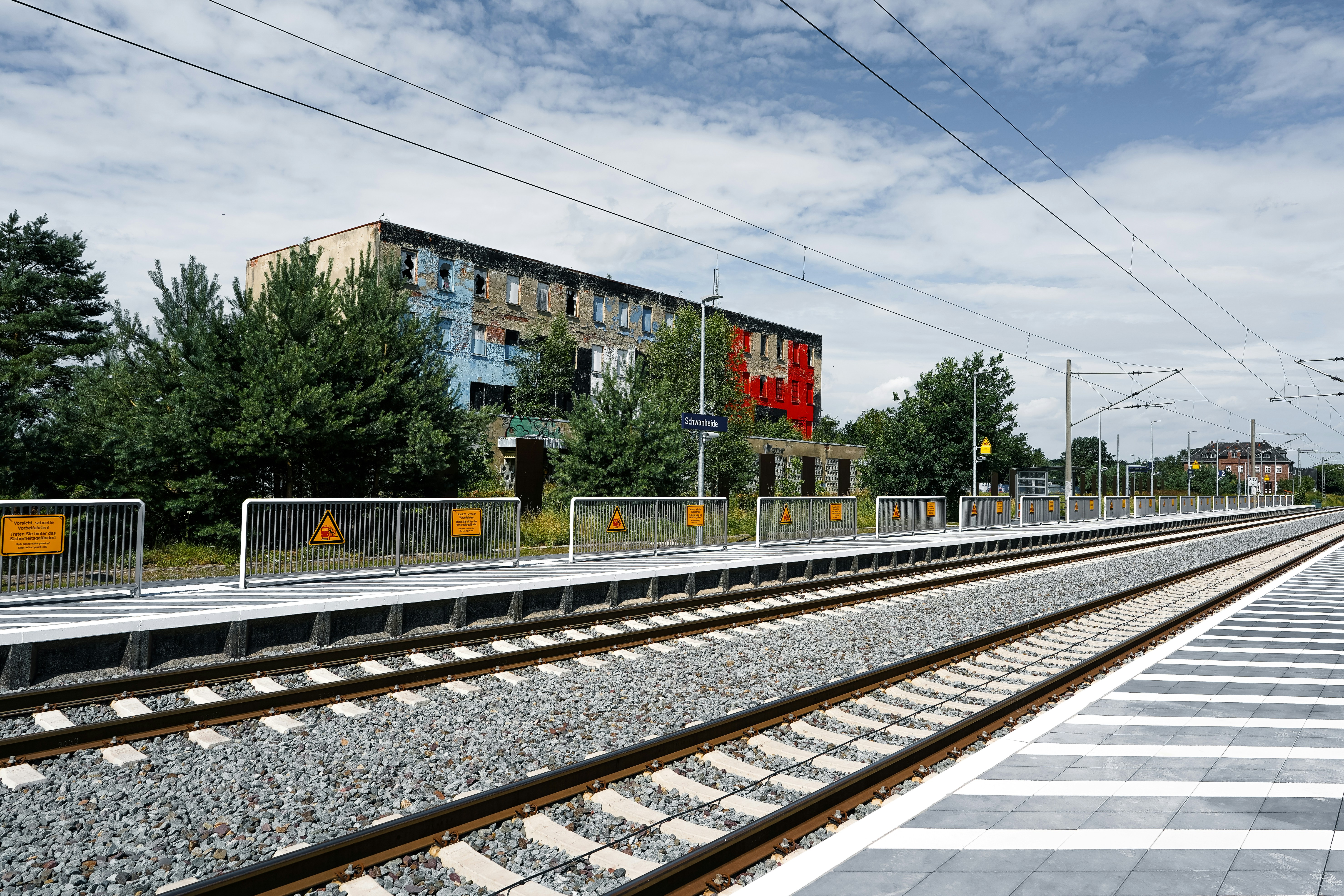 Abandoned Facade Greeted by Rails: A Quiet Station of Forgotten Industry