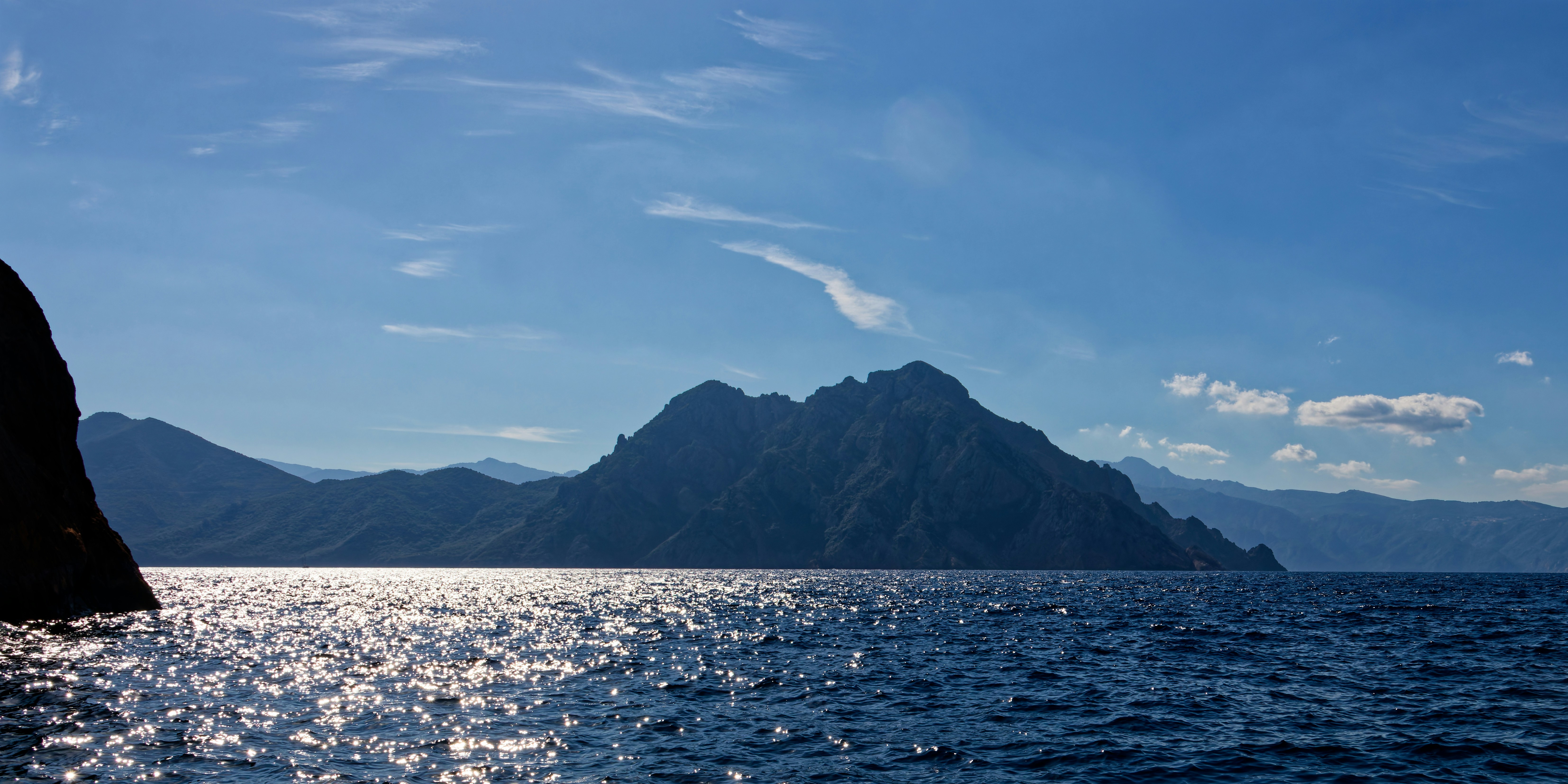 Isolated Island Crowned by Peaks Across Quiet Seas
