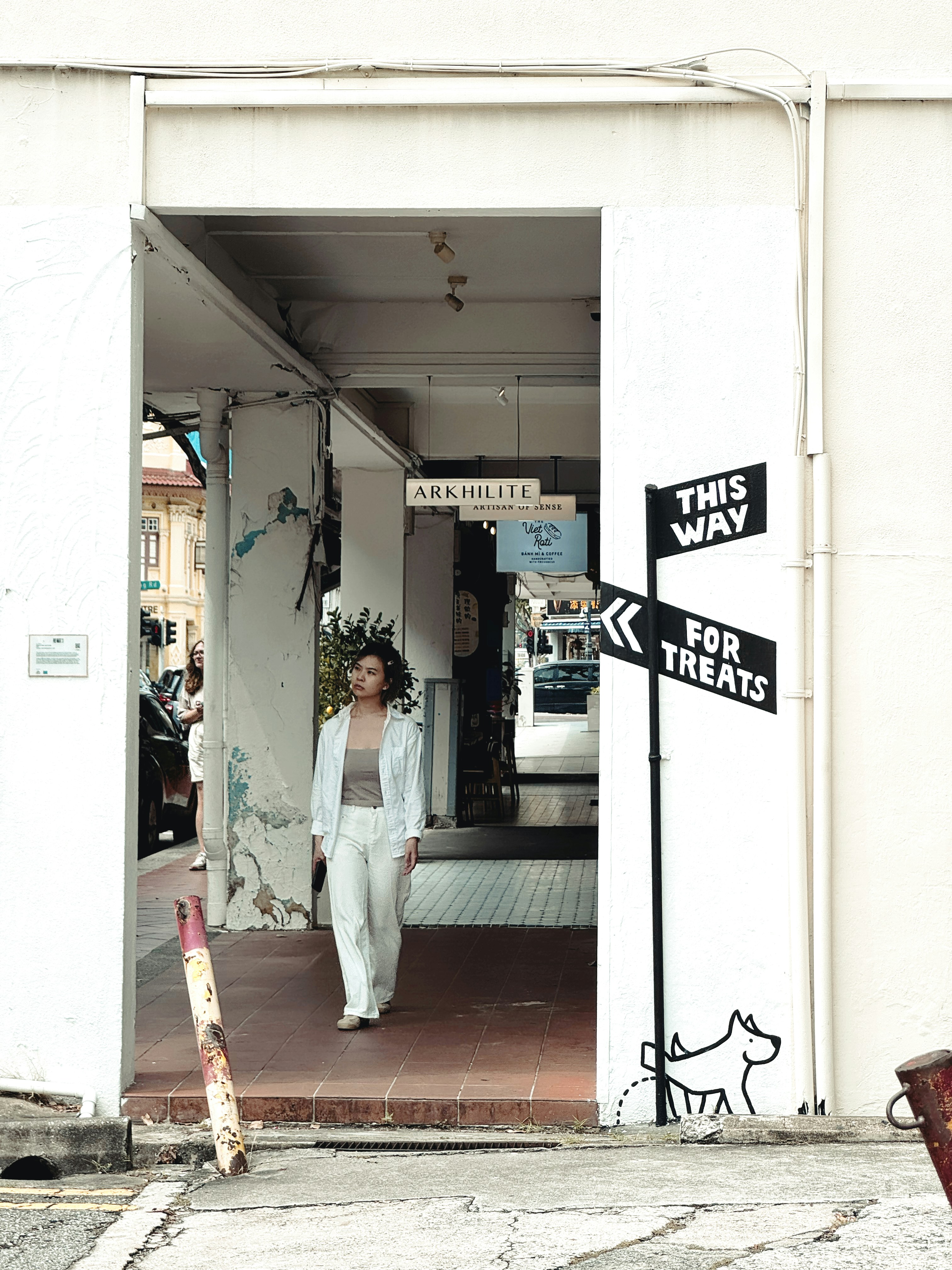Urban Threshold: A Woman Steps Into the Light From a Painted Archway
