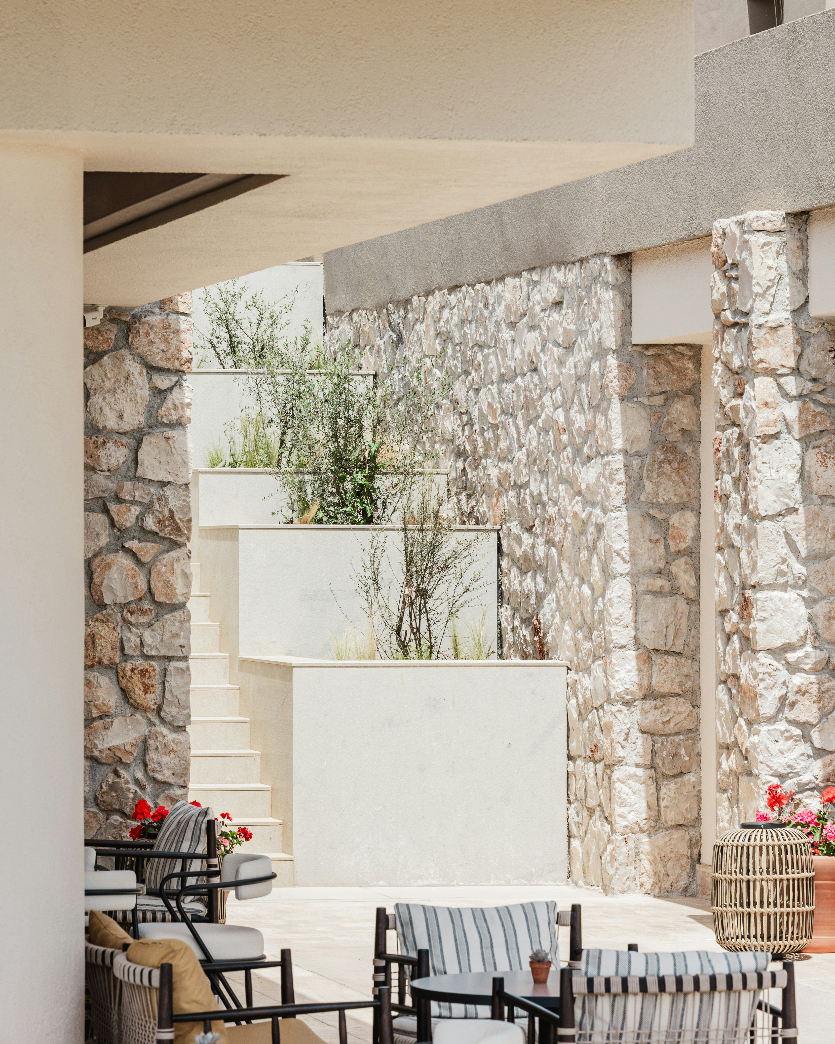 Staircase Corridor Framed by Stone Walls and Courtyard Seating