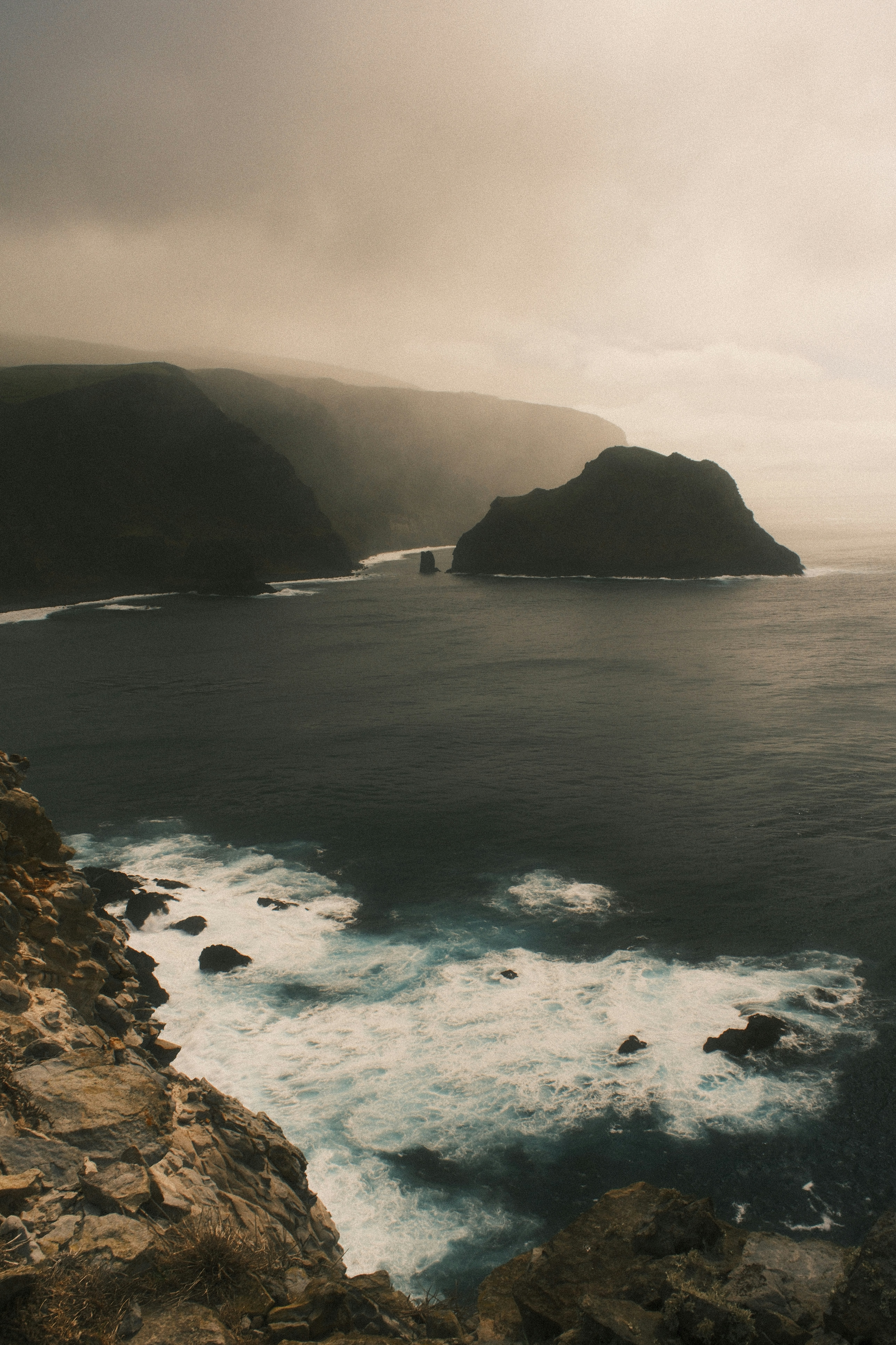 Mist-Shrouded Sea Stacks within a Coastal Grotto