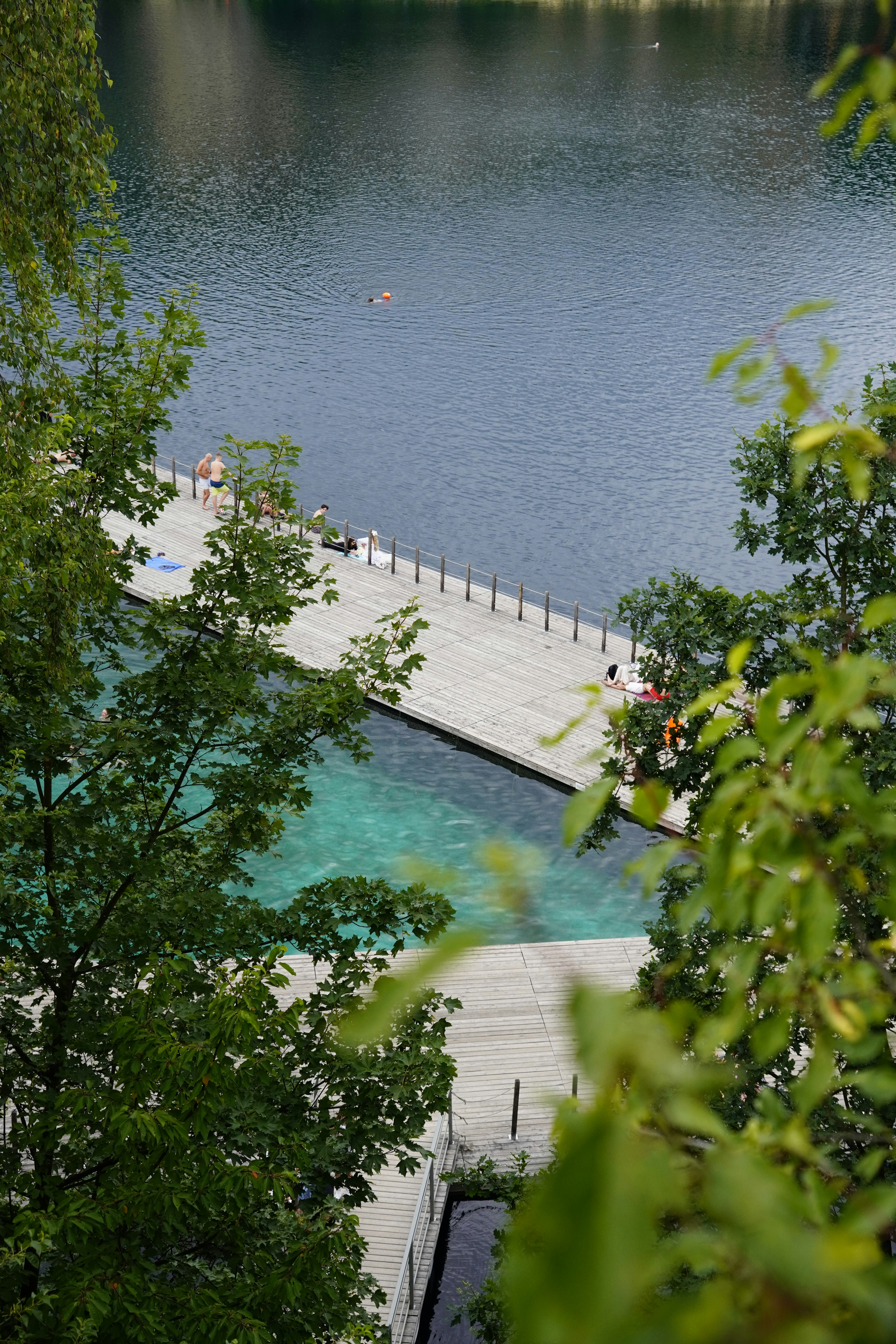 Stairs to turquoise water: a lakefront boardwalk framed by trees