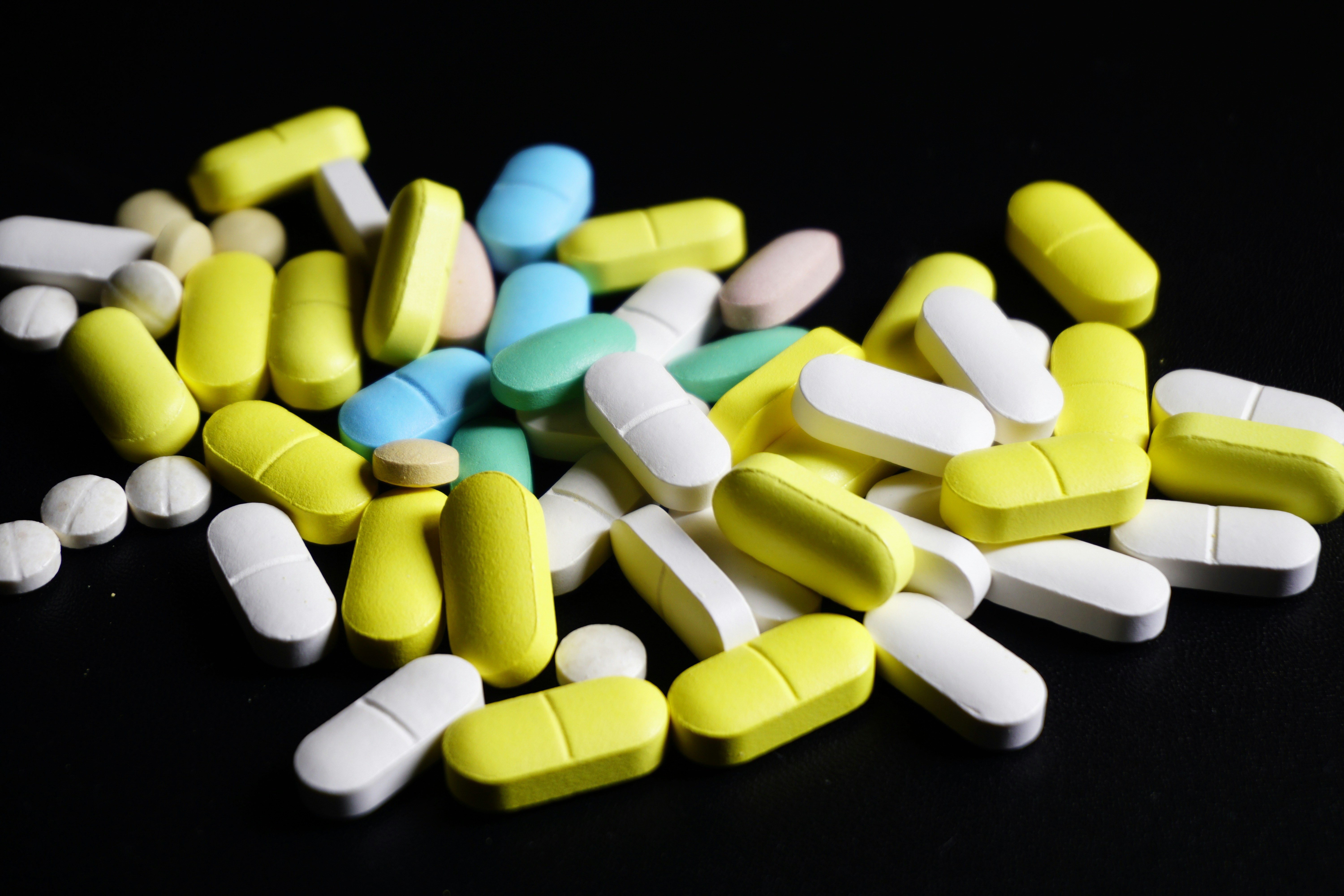Pile of assorted capsules on a dark backdrop