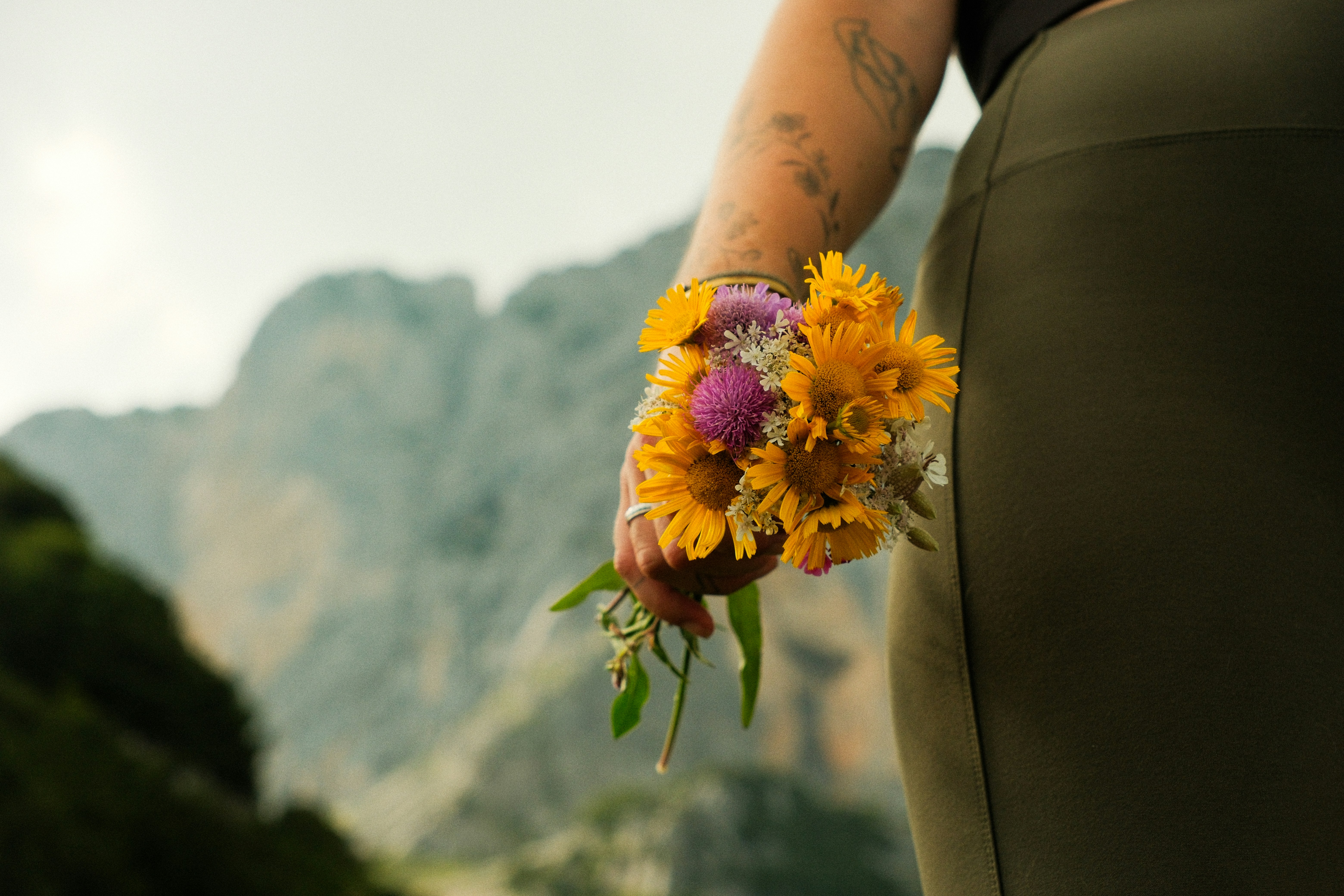 Bouquet of Contrast: Wildflowers in Hand by a Hiking Path