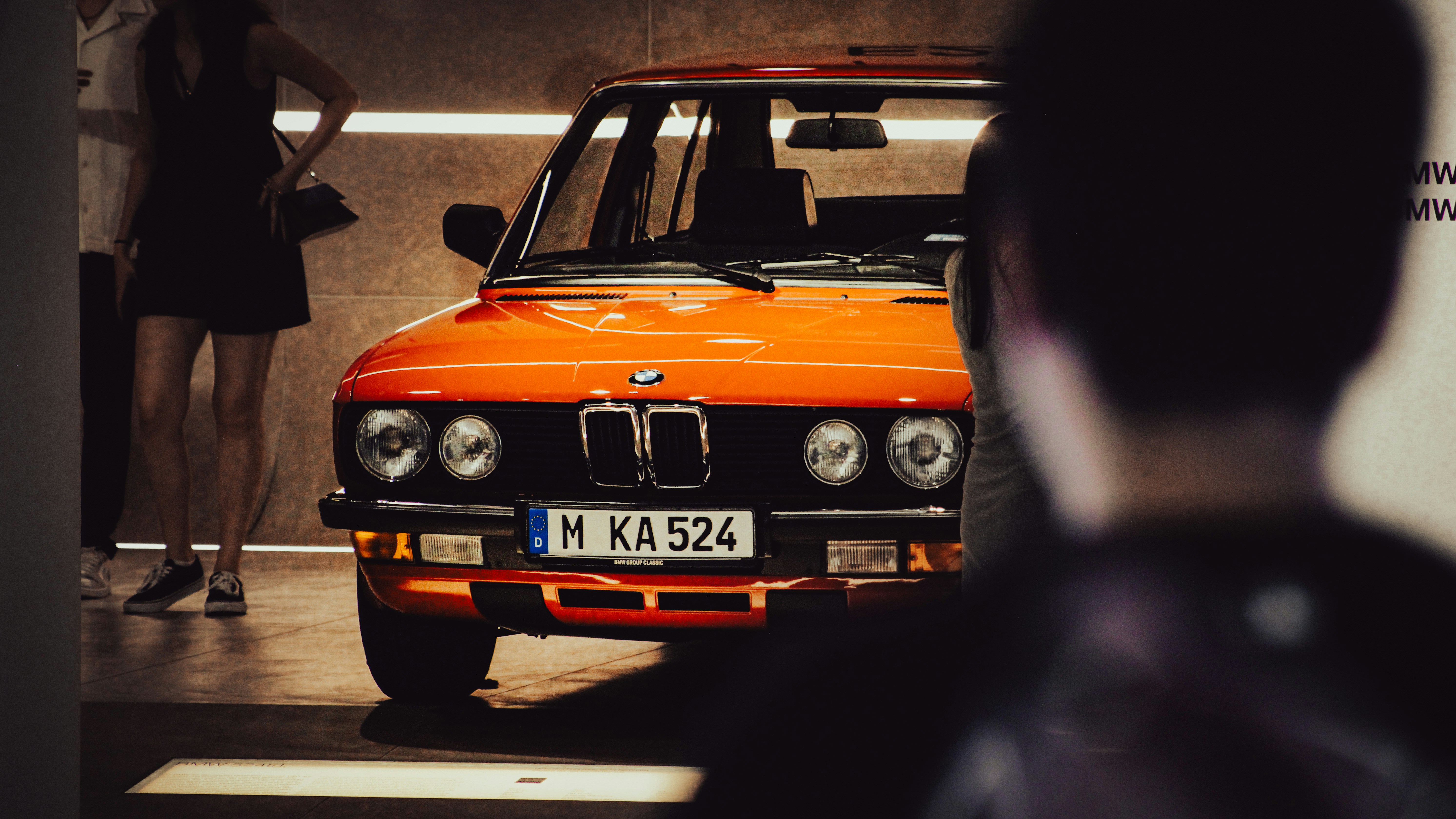 Red Classic in the Spotlight: A Vintage BMW at a Showroom Pause