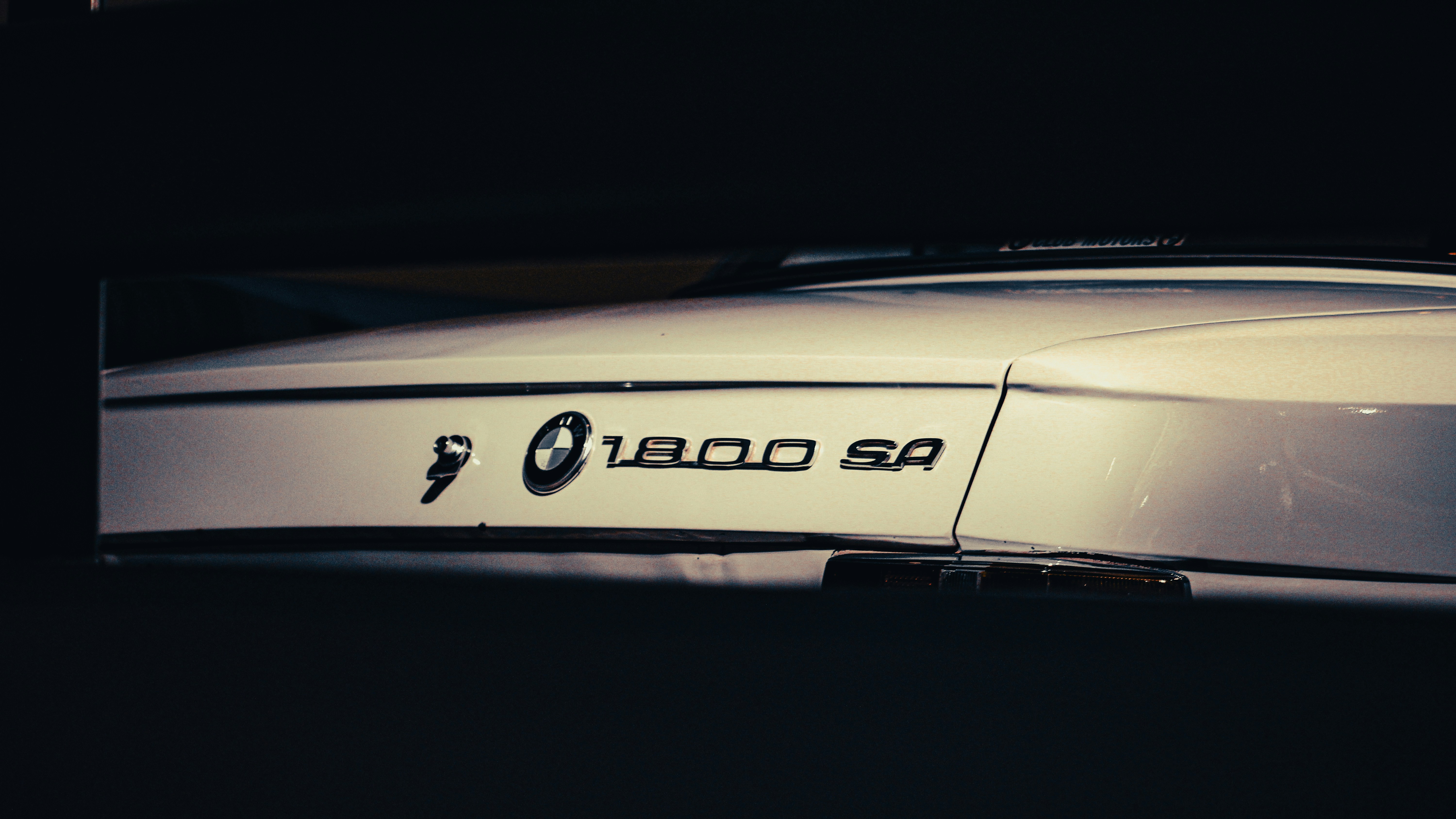 Emblem Under Moonlight: The BMW 1800 S Badge in Shadow