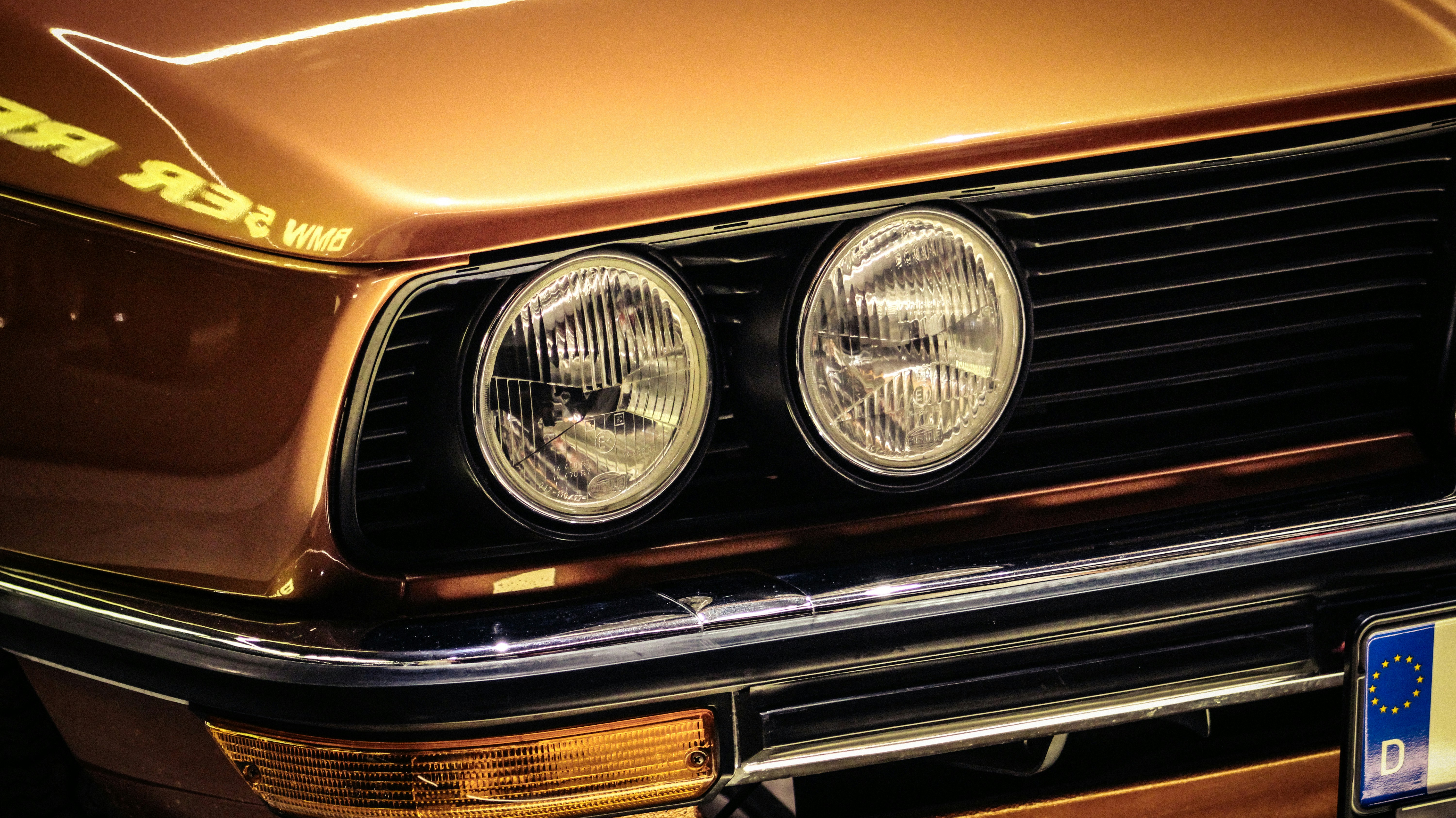 Copper Curves: A classic car’s chrome stare under warm evening light