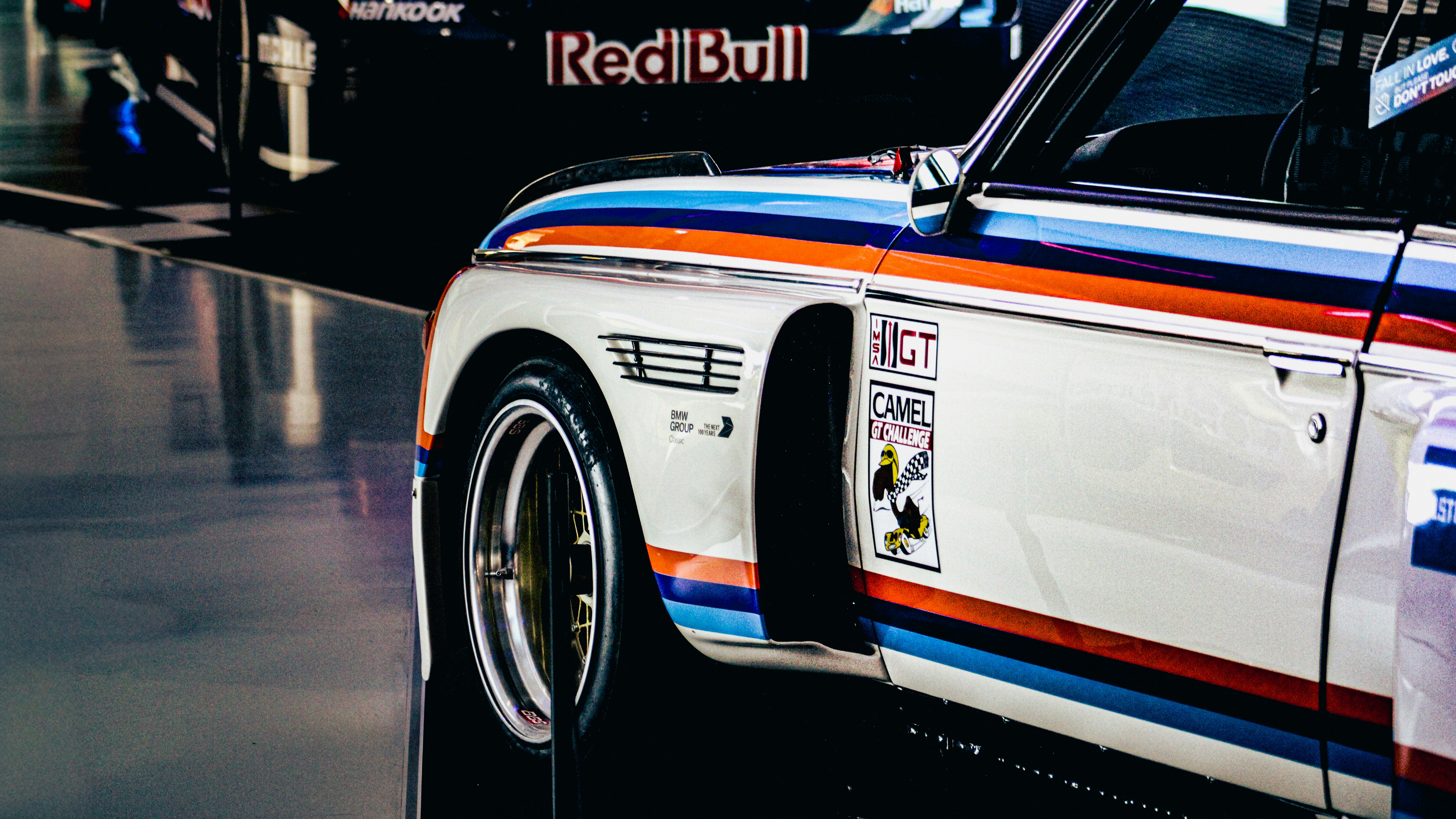 Striped race-car silhouette: chrome wheel and mid‑body badge glow
