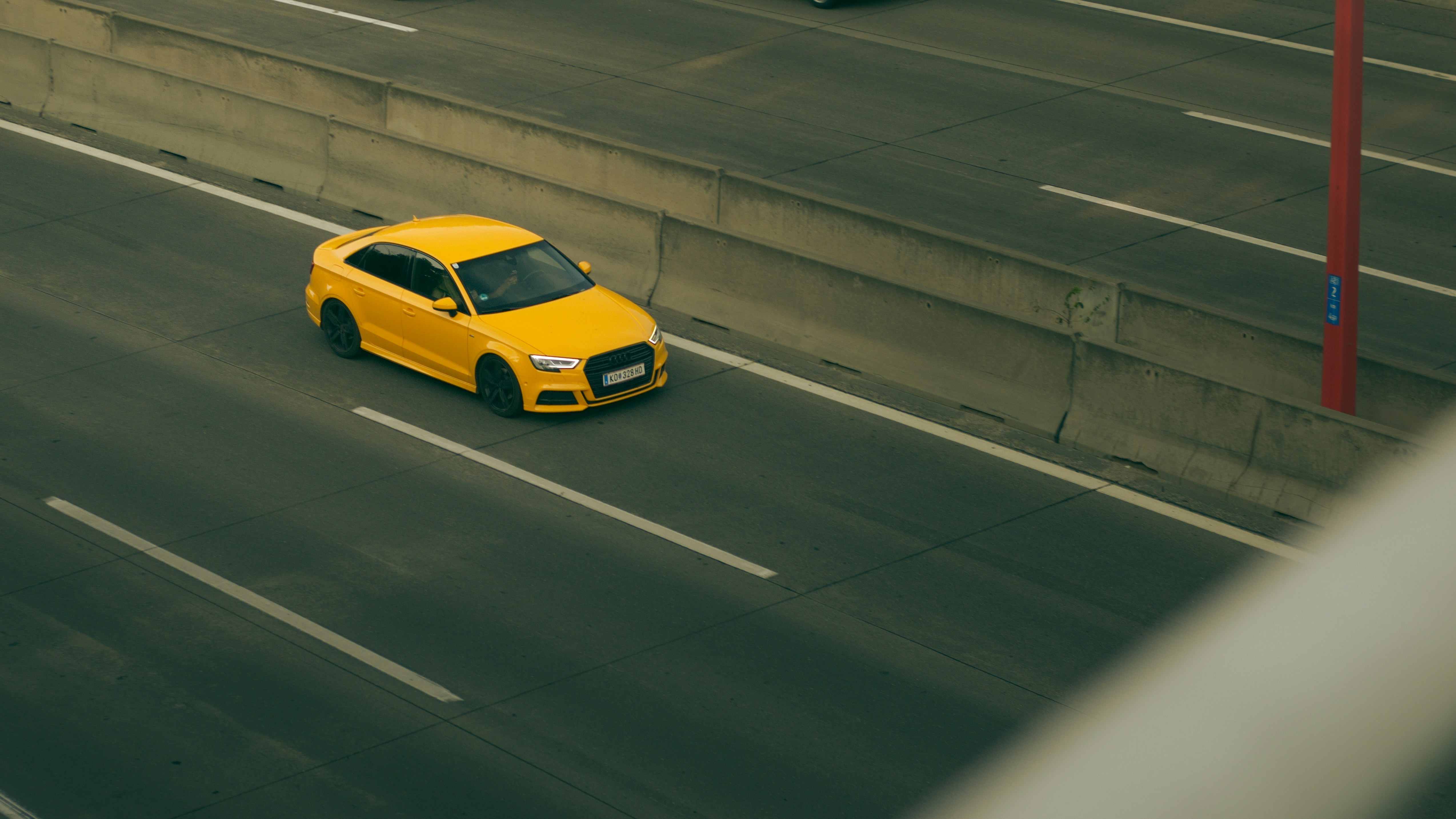 Yellow taxi cutting through the urban highway