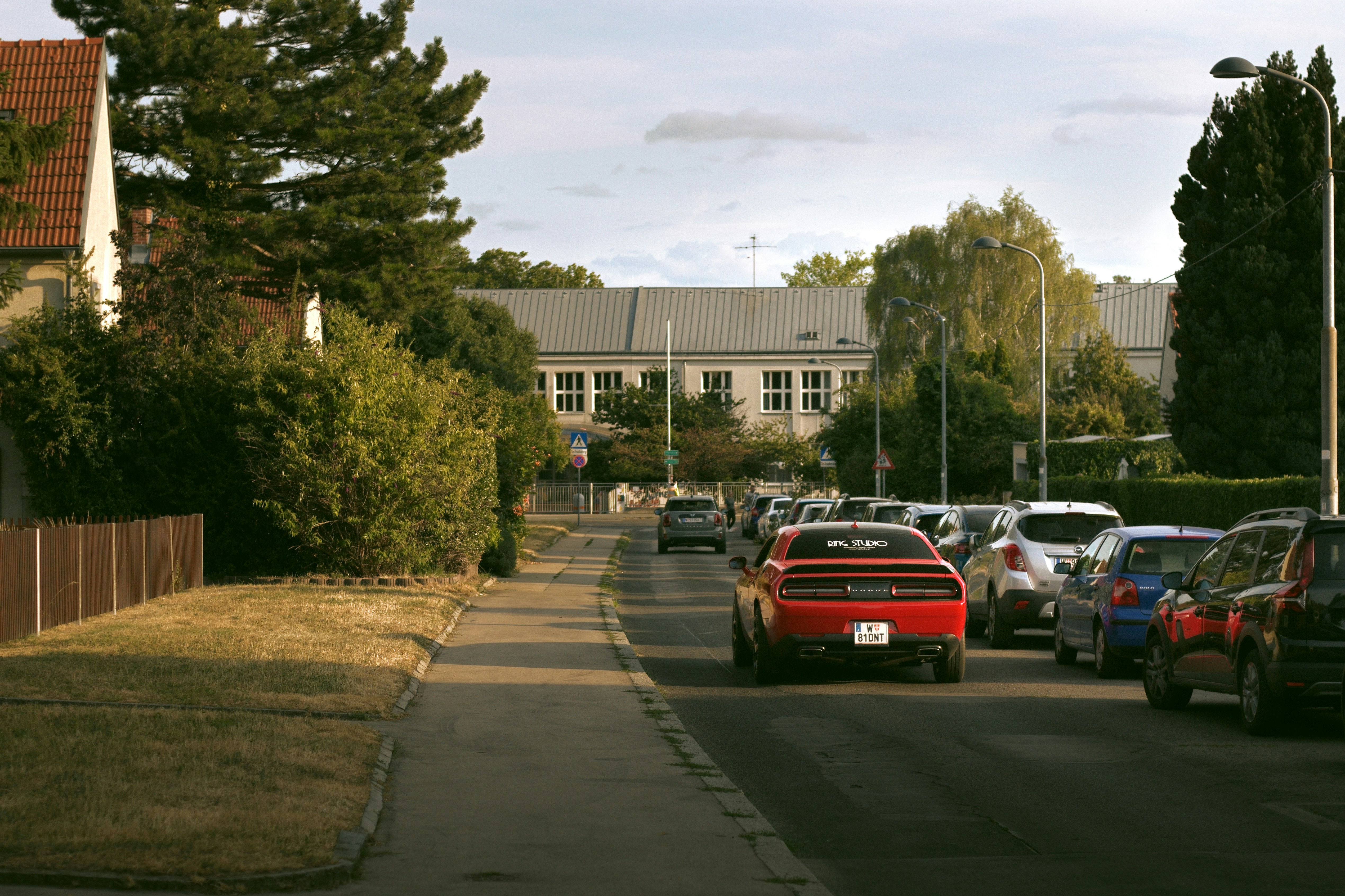 Red SUV as the Street's Focal Point on a Quiet Suburban Avenue