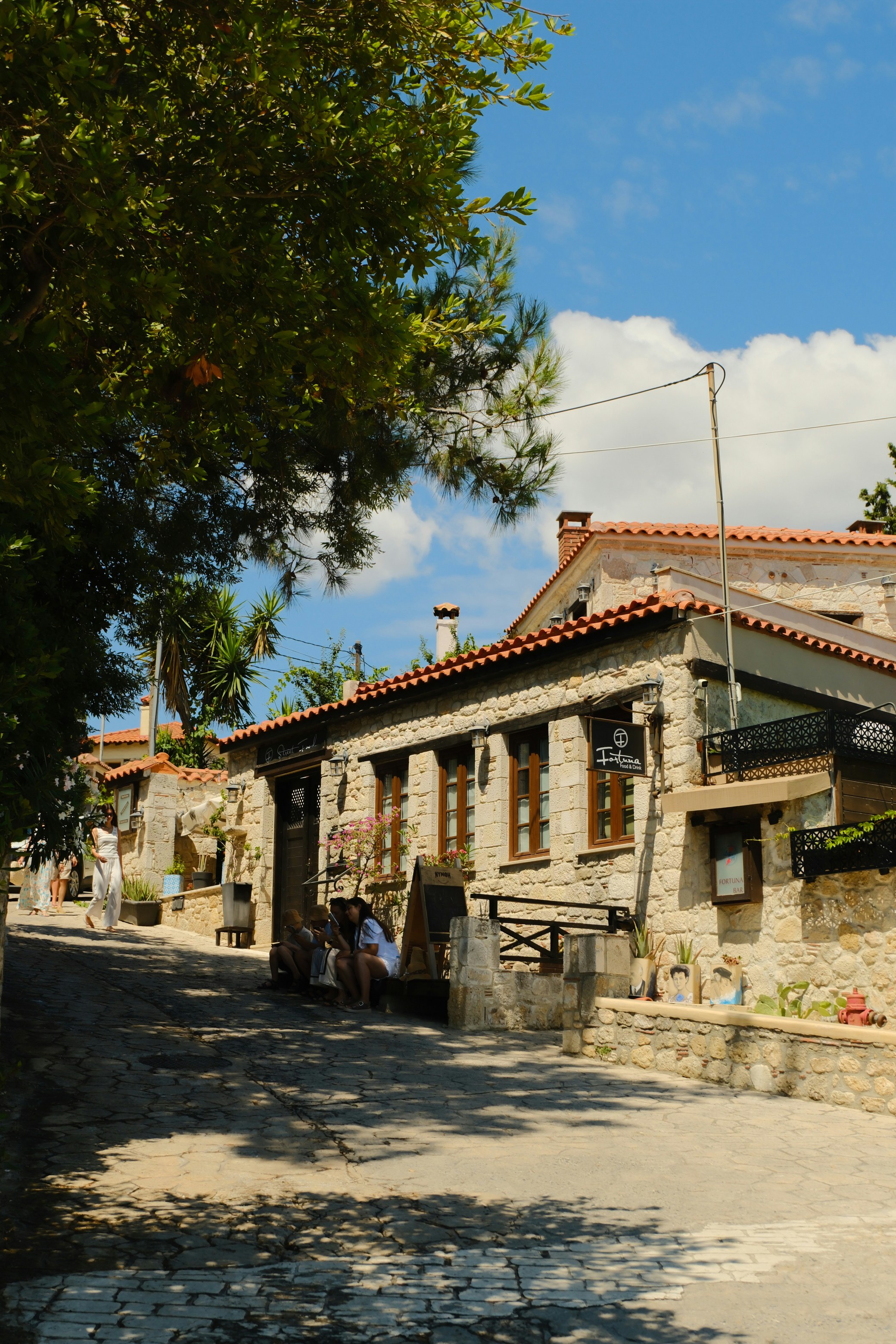 Sunlit stone village along a winding cobblestone lane